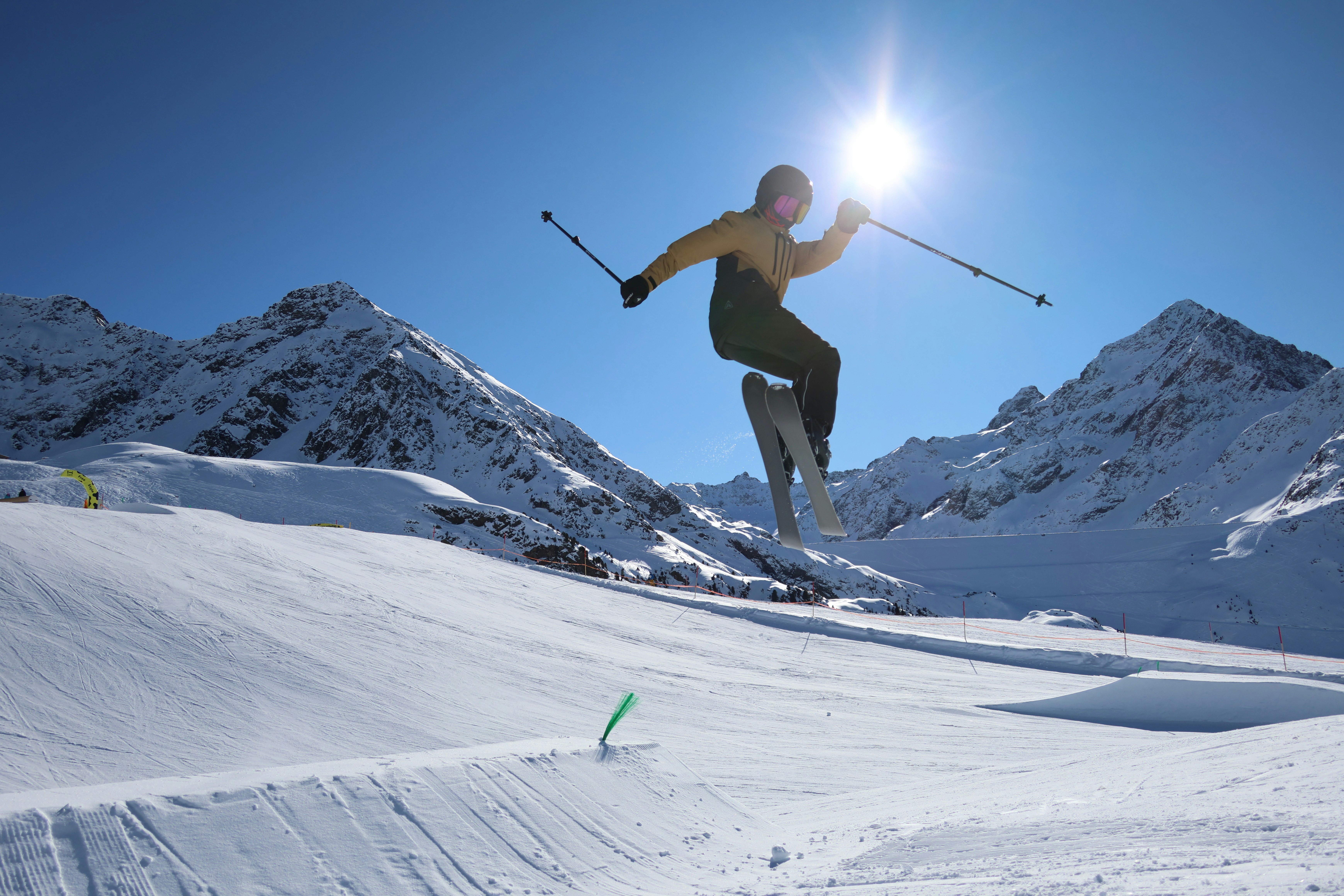 Airborne in the Alps: Skier Seizes the White Corridor Under a Brilliant Sun