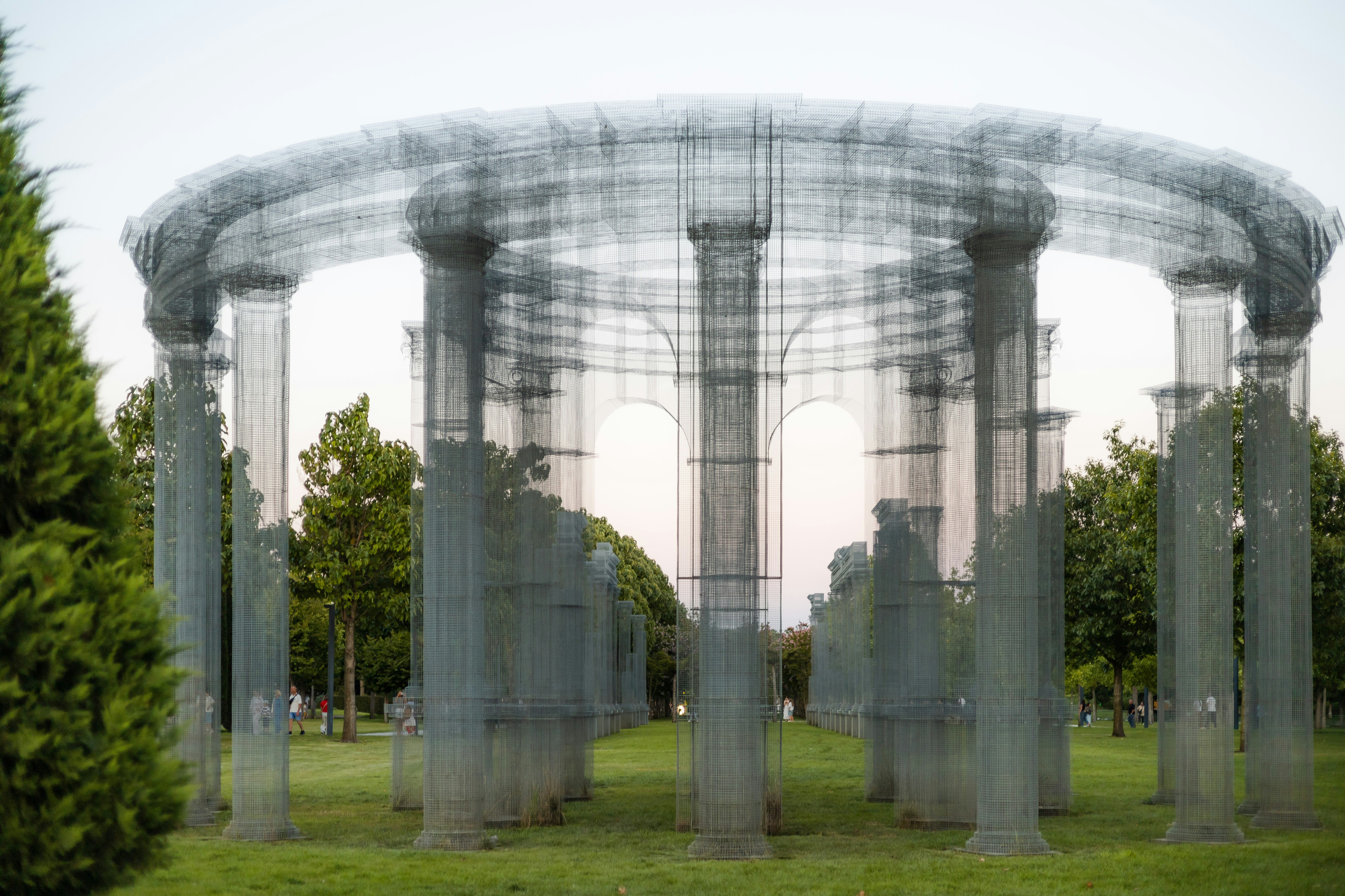 Circular Steel Rings Encircle a Lawn of Silent Columns