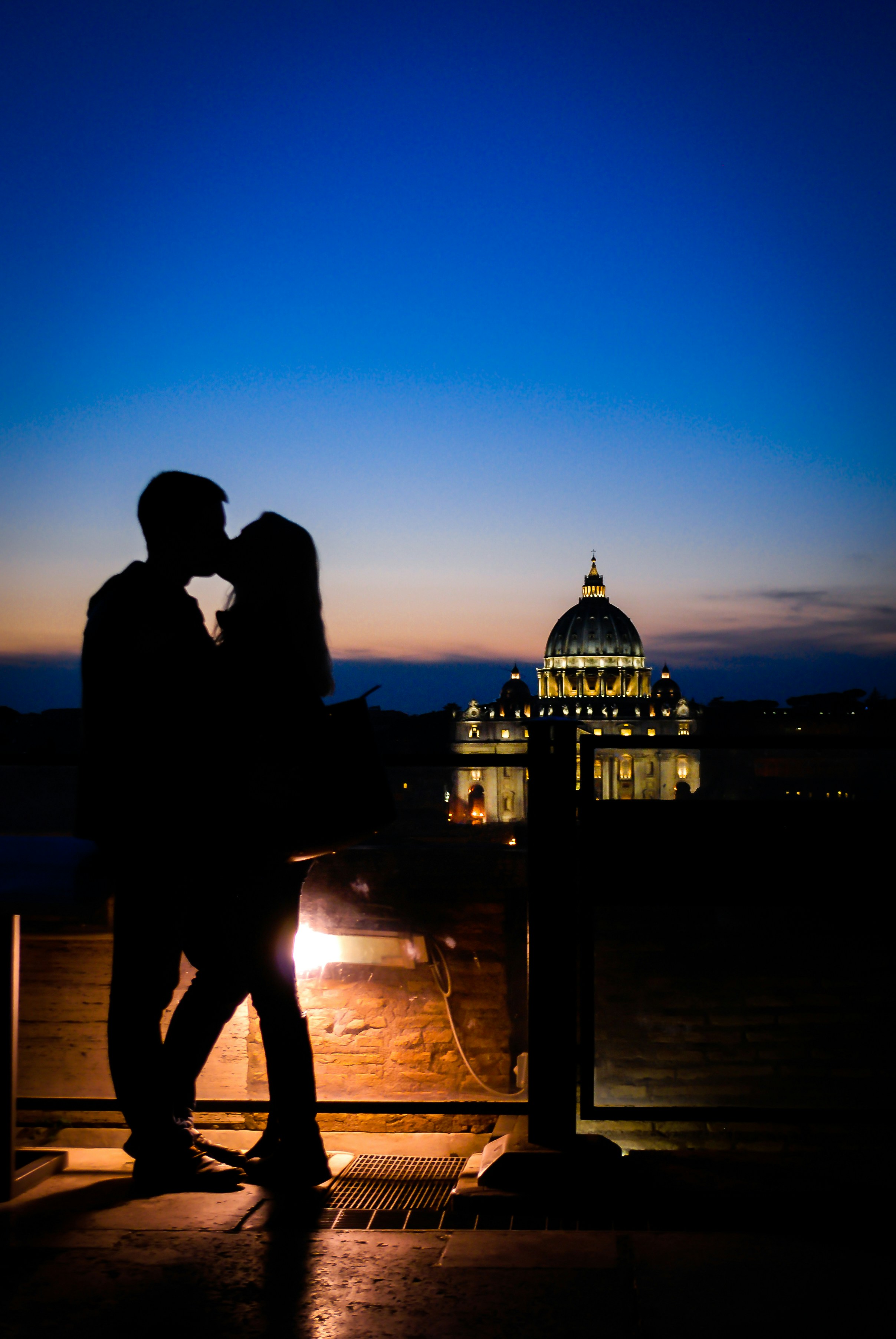 Silhouette Kiss Above Rome: Lovers on the Rooftop with St. Peter's Dome