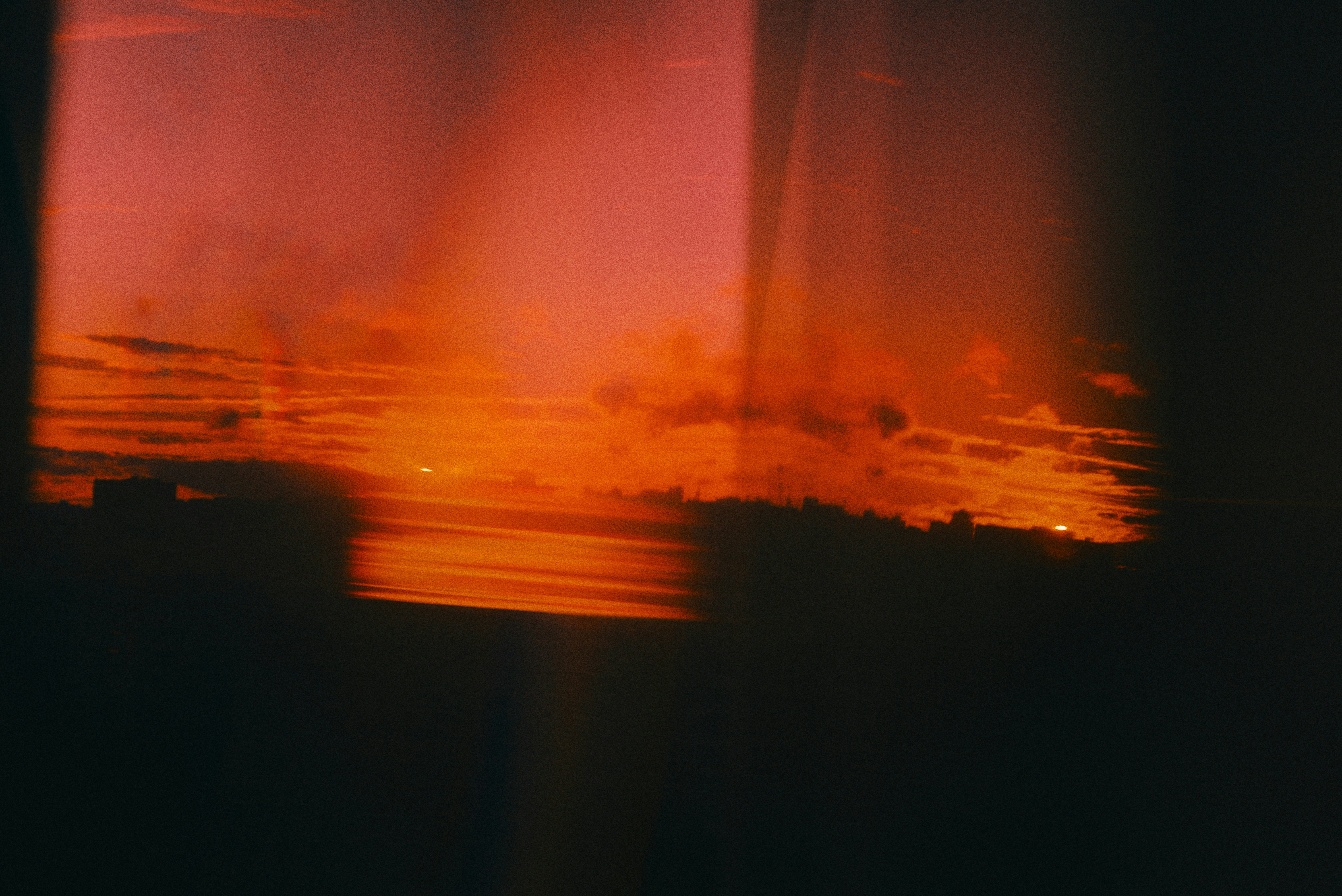 Crimson Horizon Through a Veiled Window