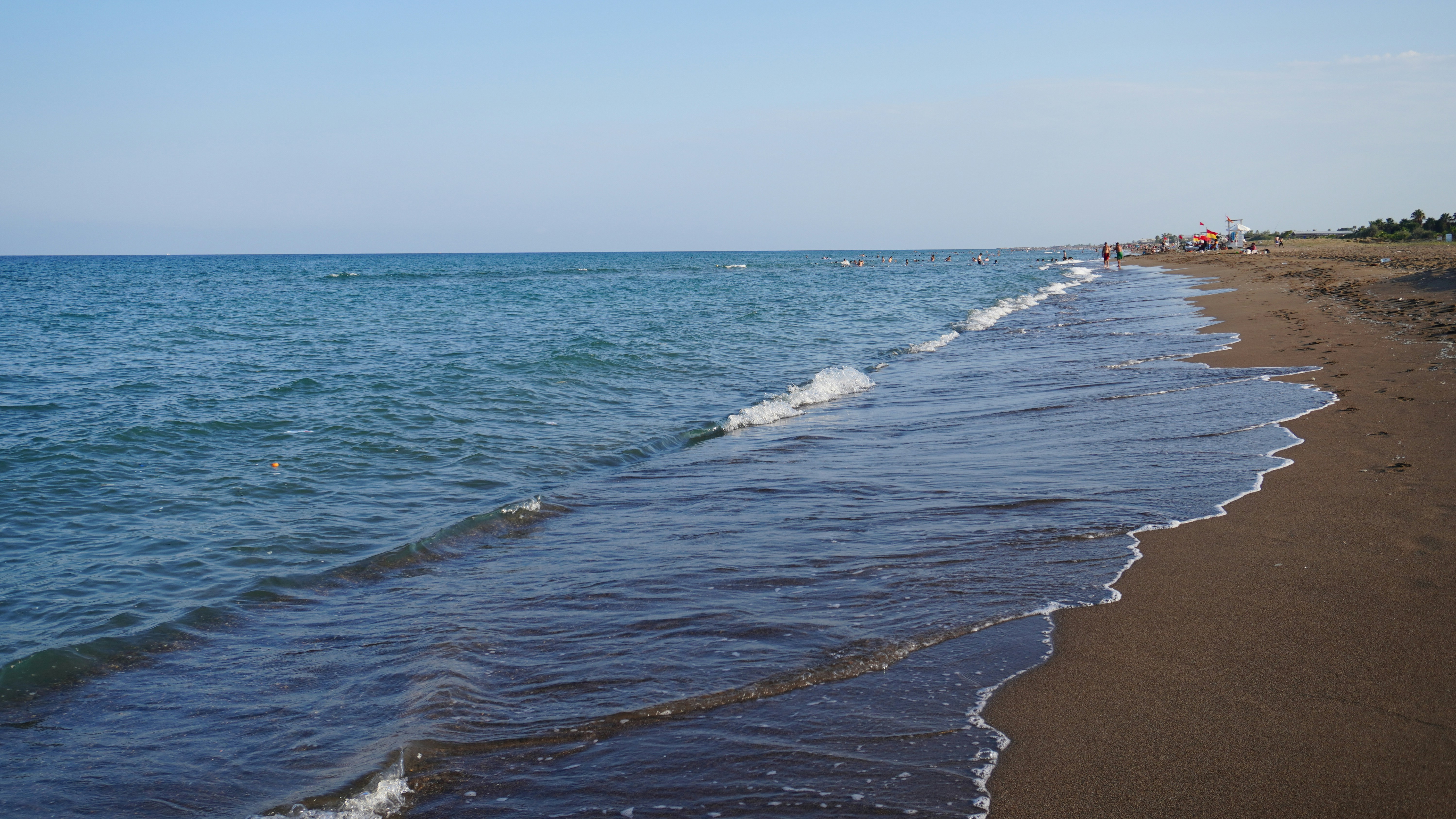 Coastal Quiet: Weaving Shoreline Light Along a Calm Blue Sea