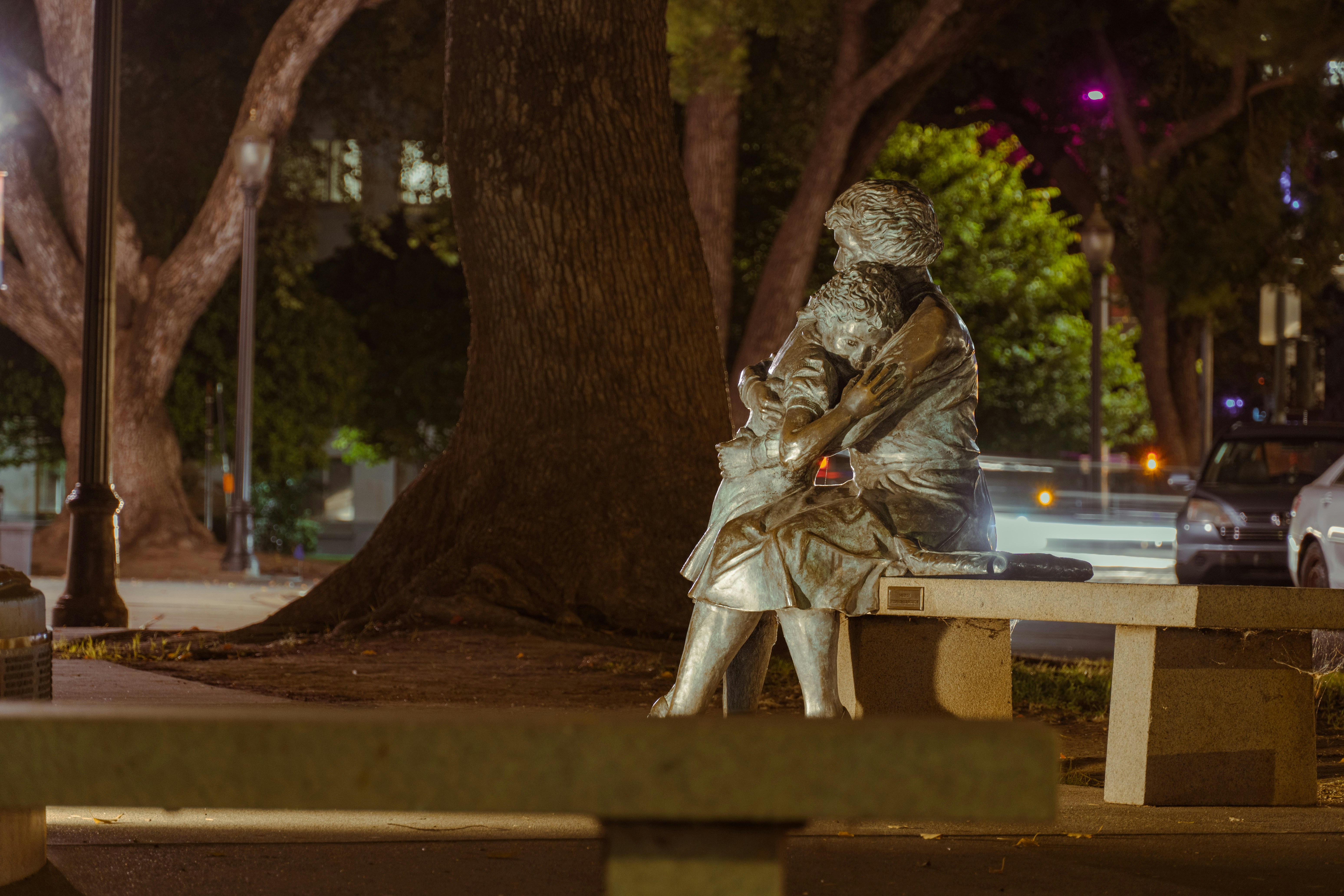 Nighttime Bench: A Silver Figure in Quiet Urban Light