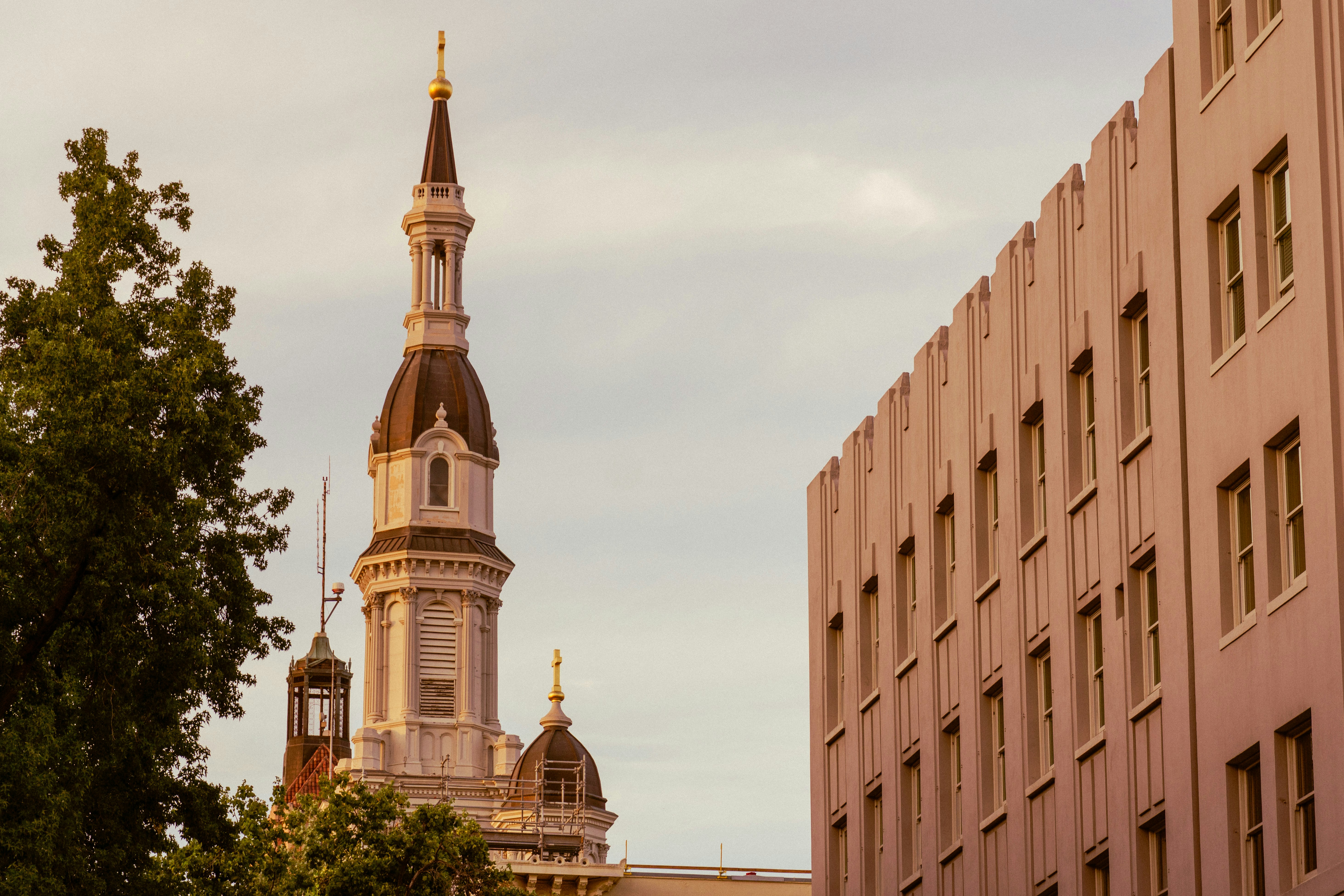 Stately spire against a modern skyline at golden hour