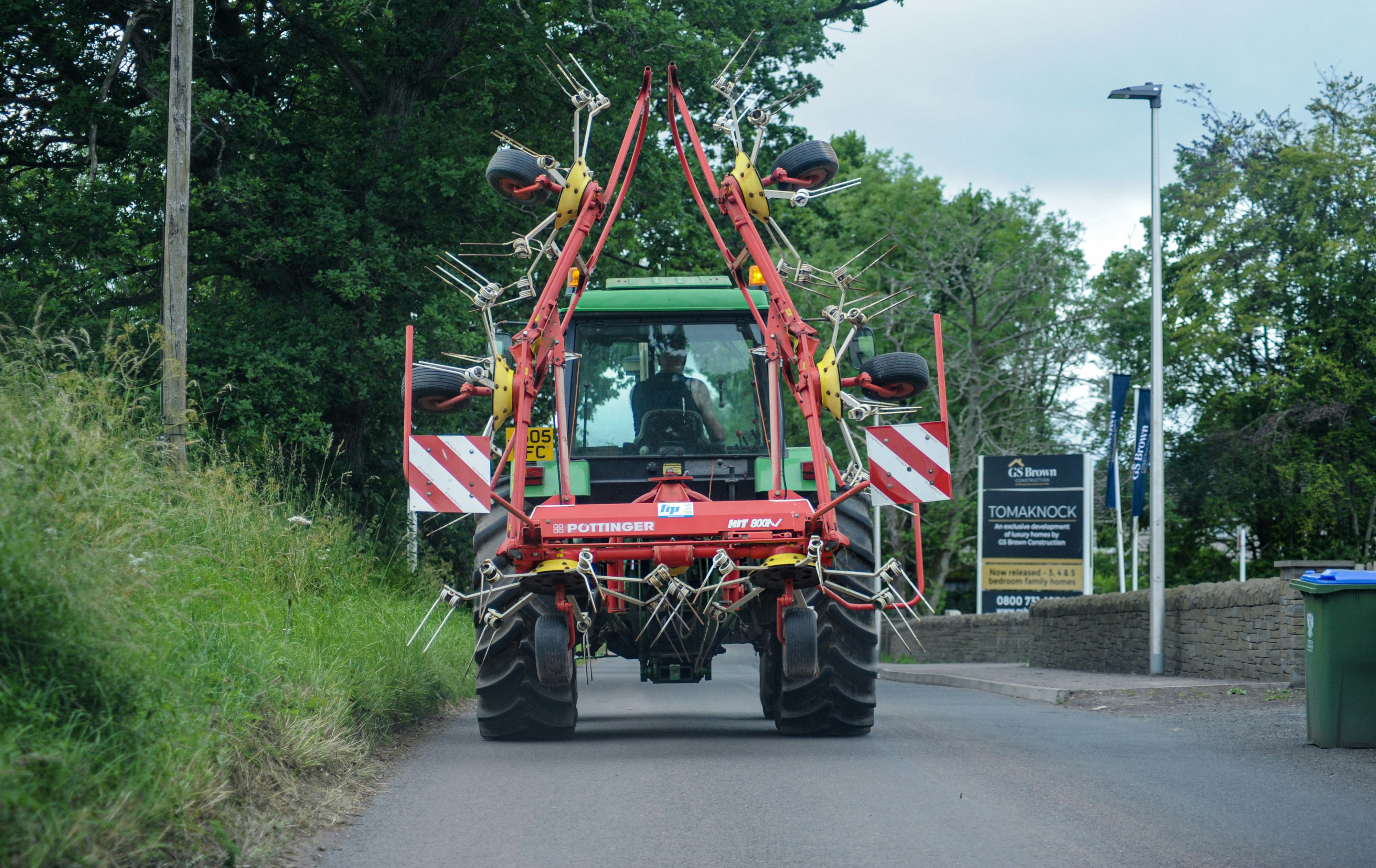 Toward a Clean Road: A Red Agricultural Machine Approaches in a Rural Drive
