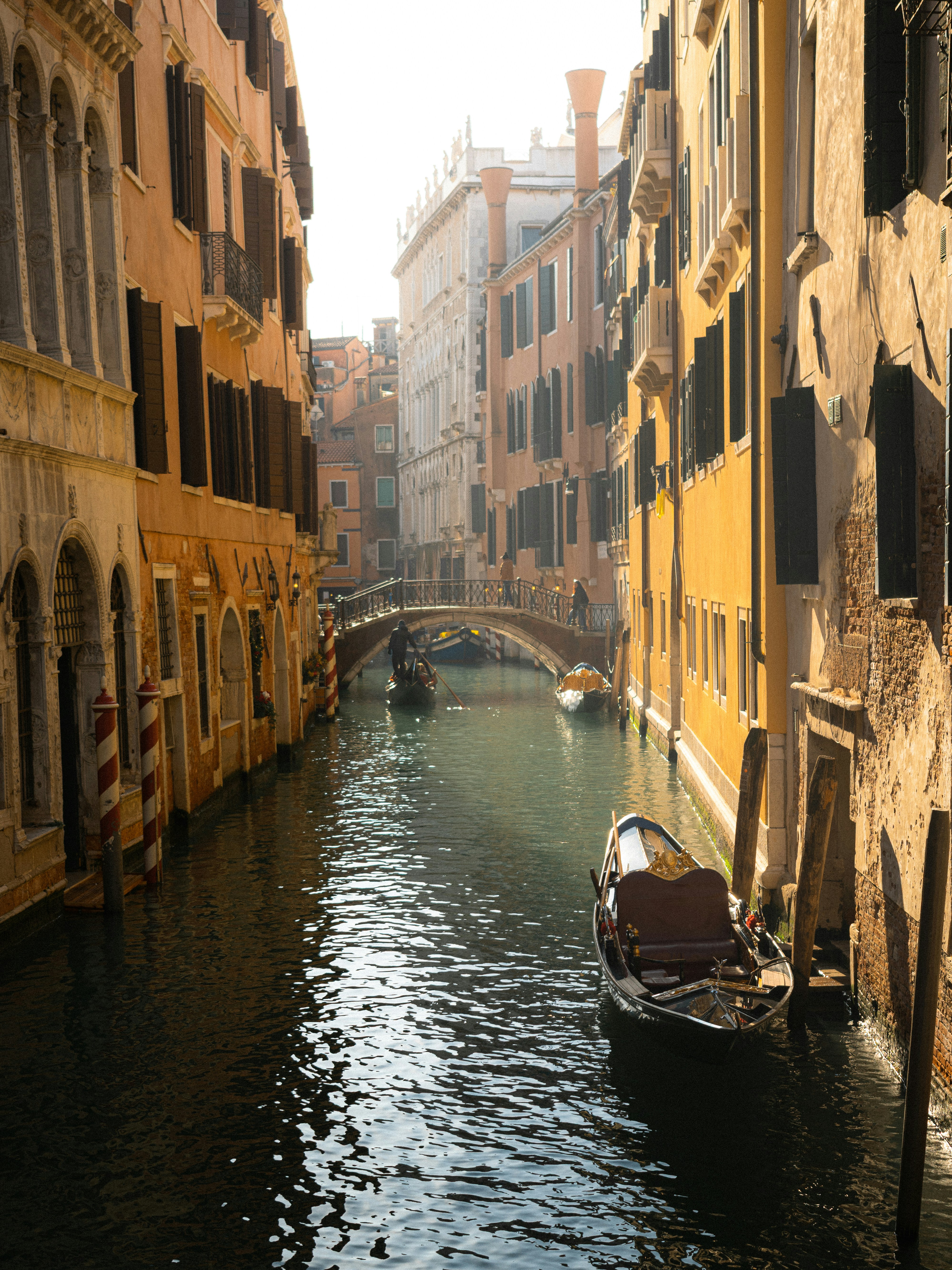 Sunlit Canal in Venice: Narrow Passageways and Golden Façades