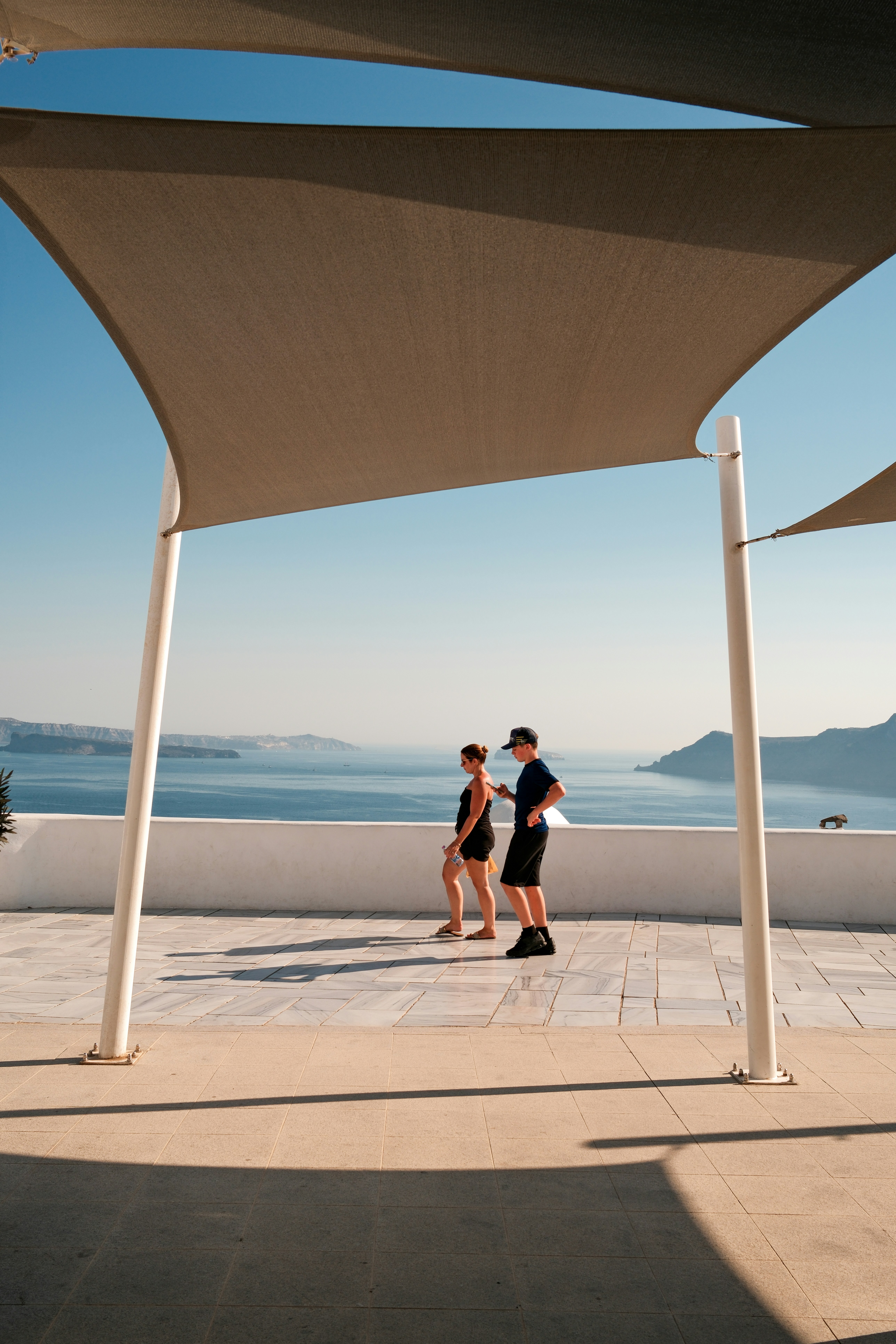 Shadows and Vista: A Seaside Promenade under Tented Canopies