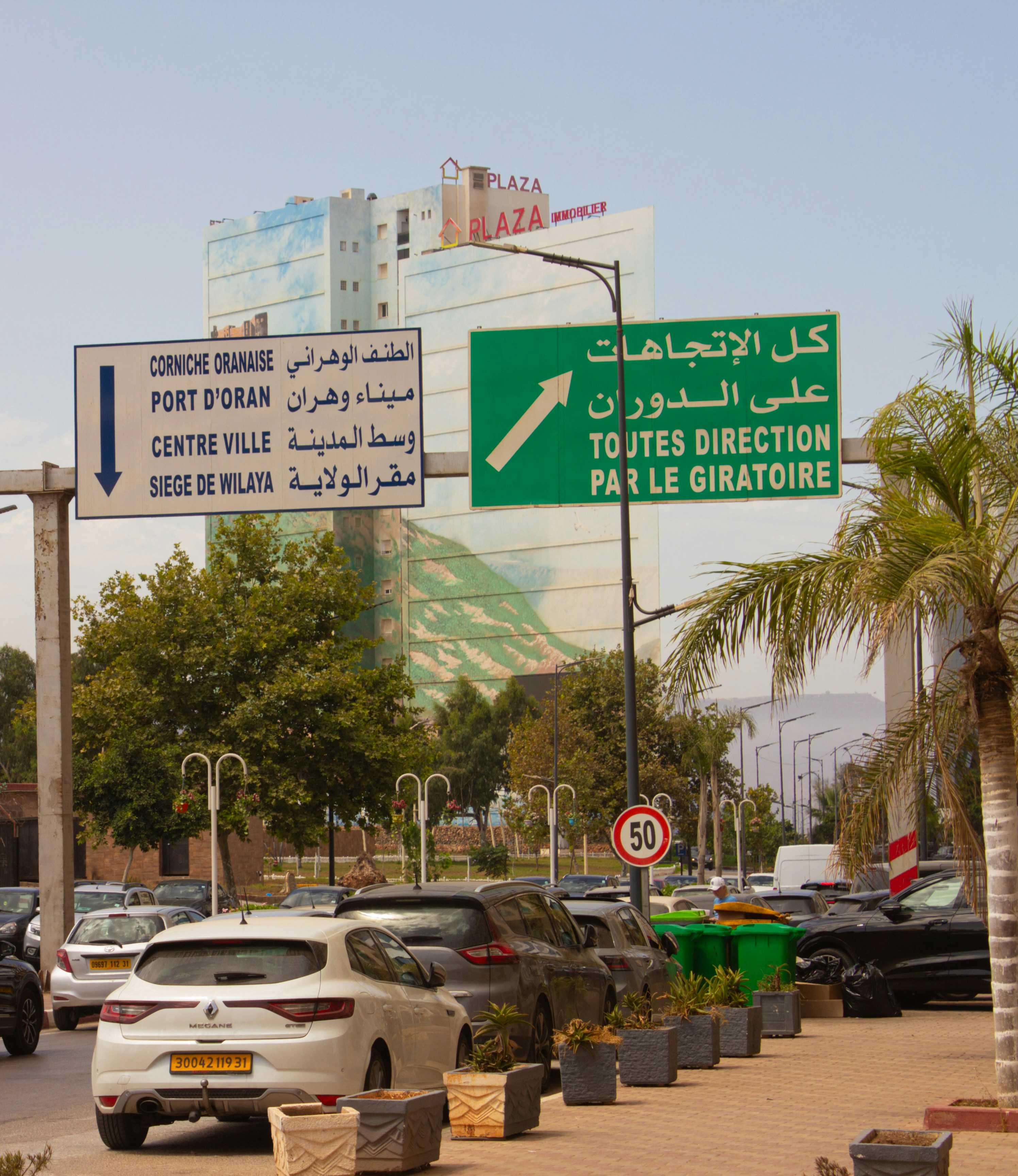 Green Signpost Leads the Way in a Busy Boulevard