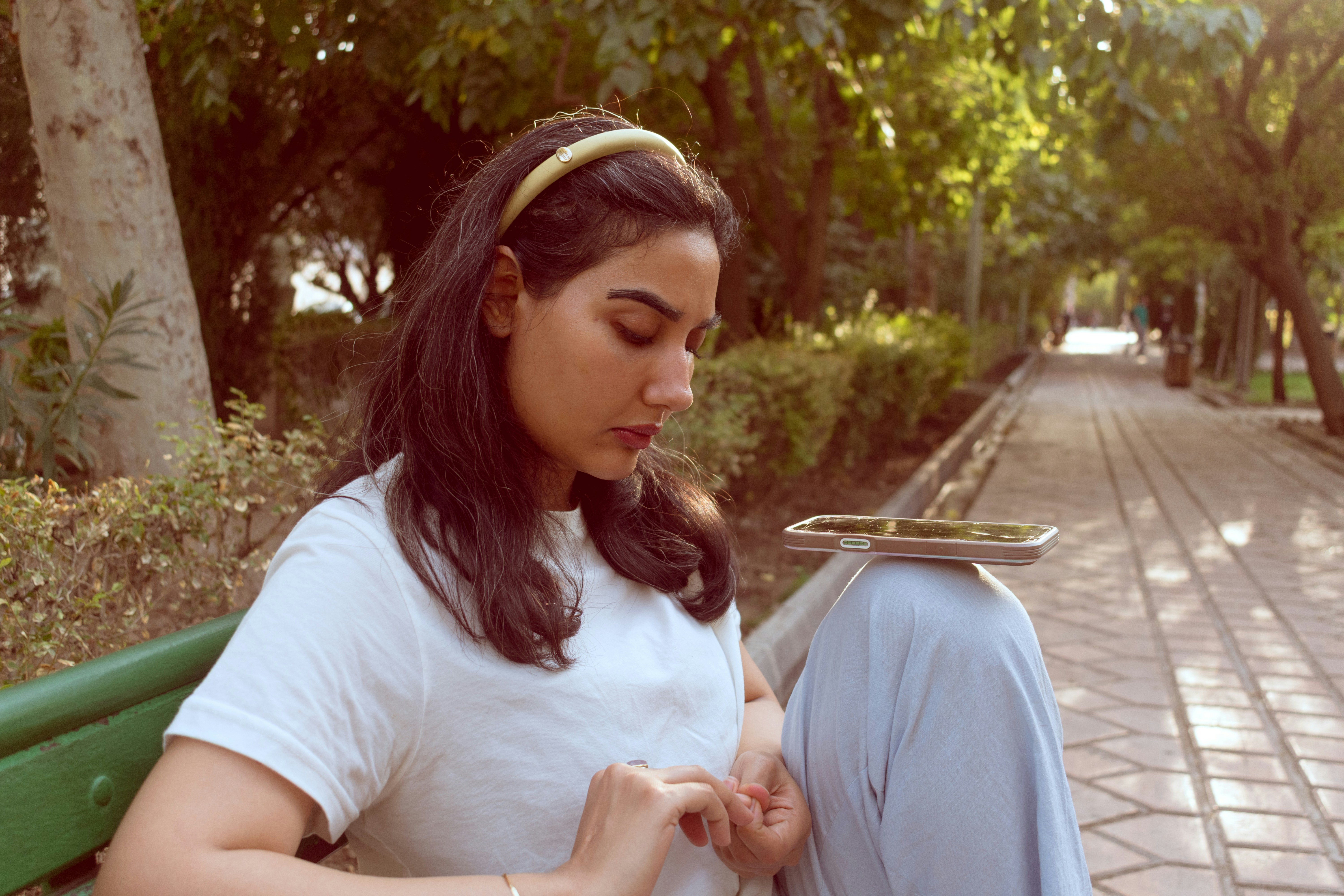 Soft Focus on a Quiet Moment: Woman with Phone Balanced on Knee