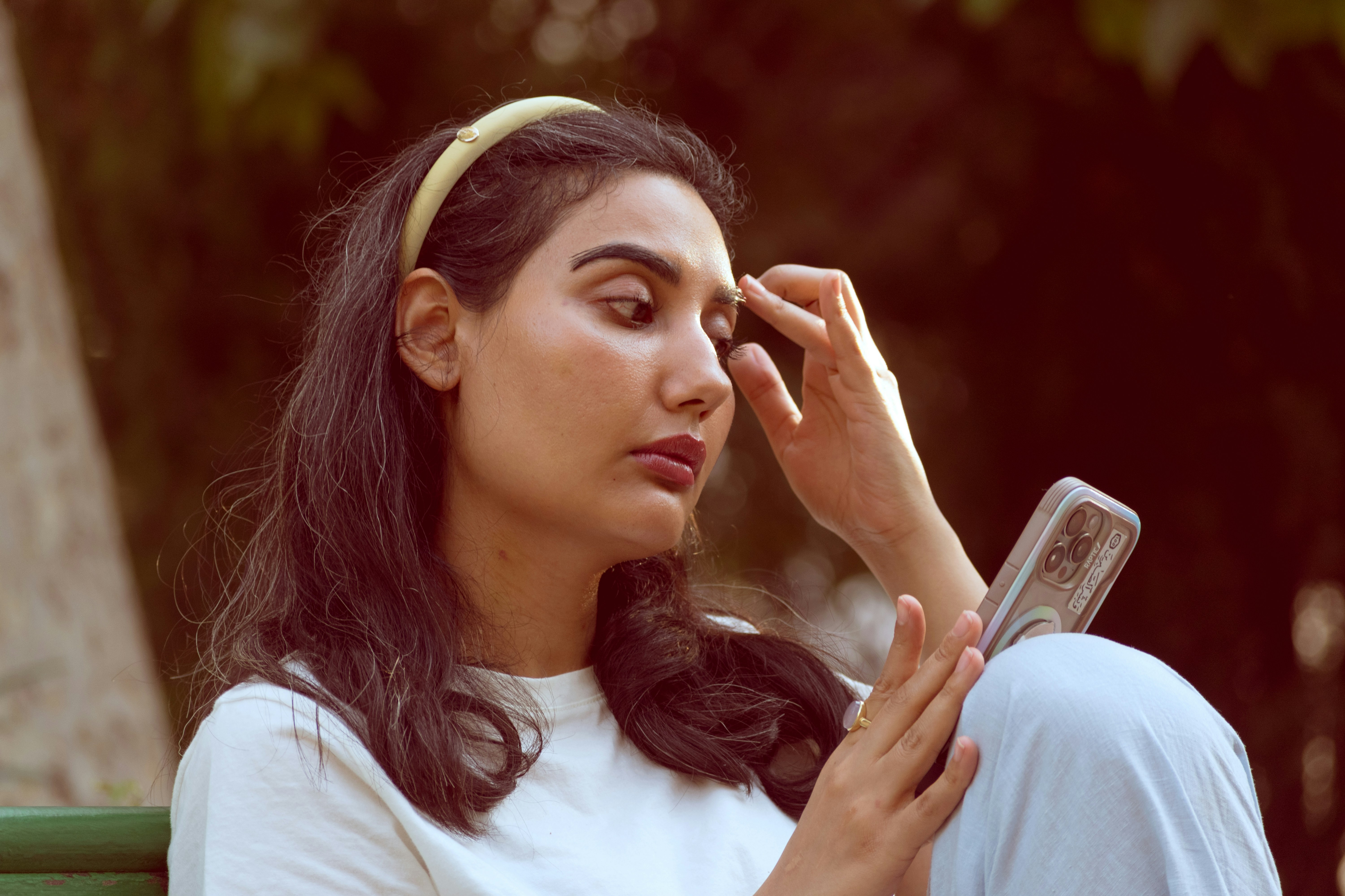 Quiet Moment: A Woman Lost in Her Phone on a Park Bench
