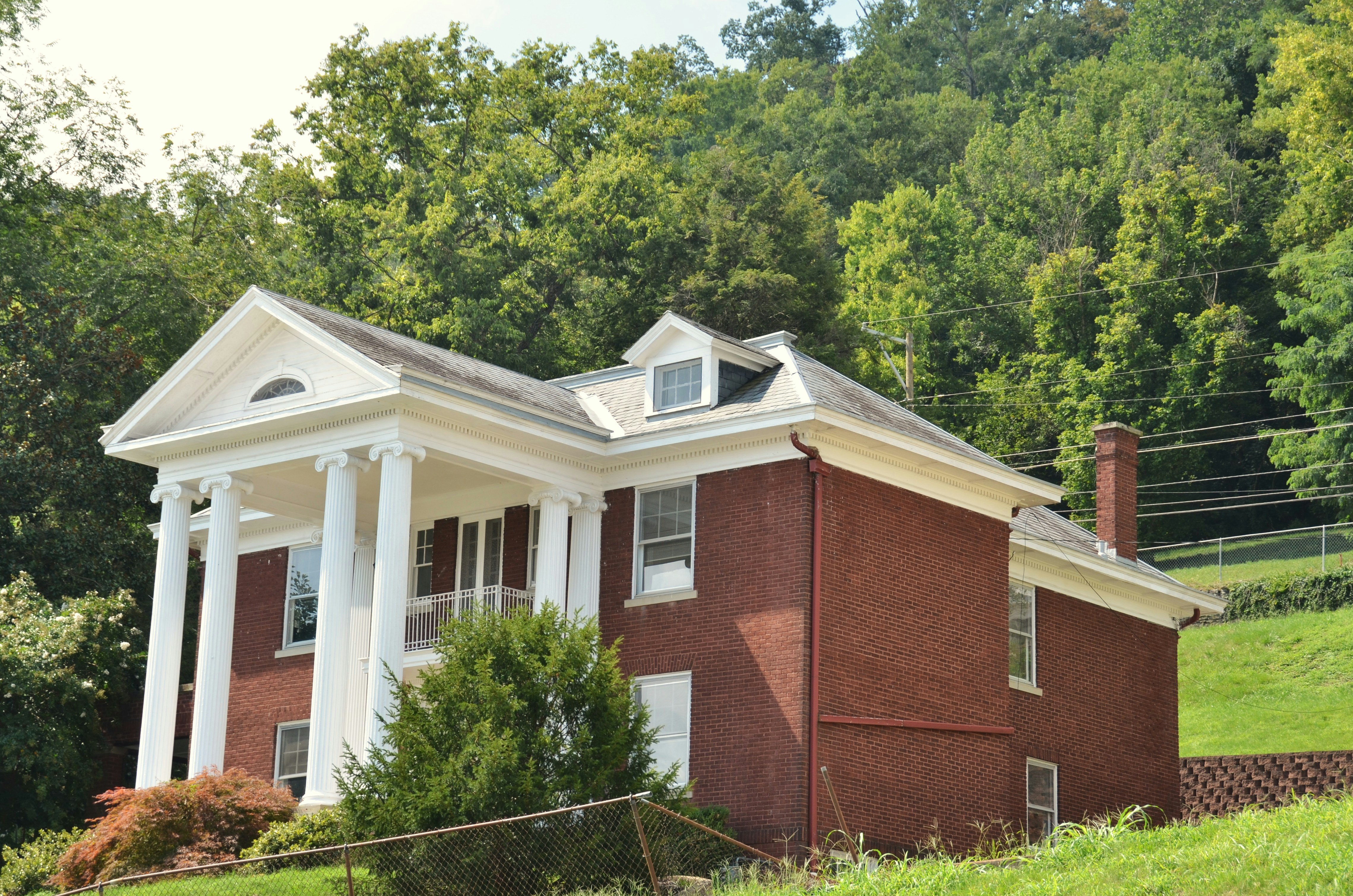 Brick House on a Sloping Hill with White Ionic Portico