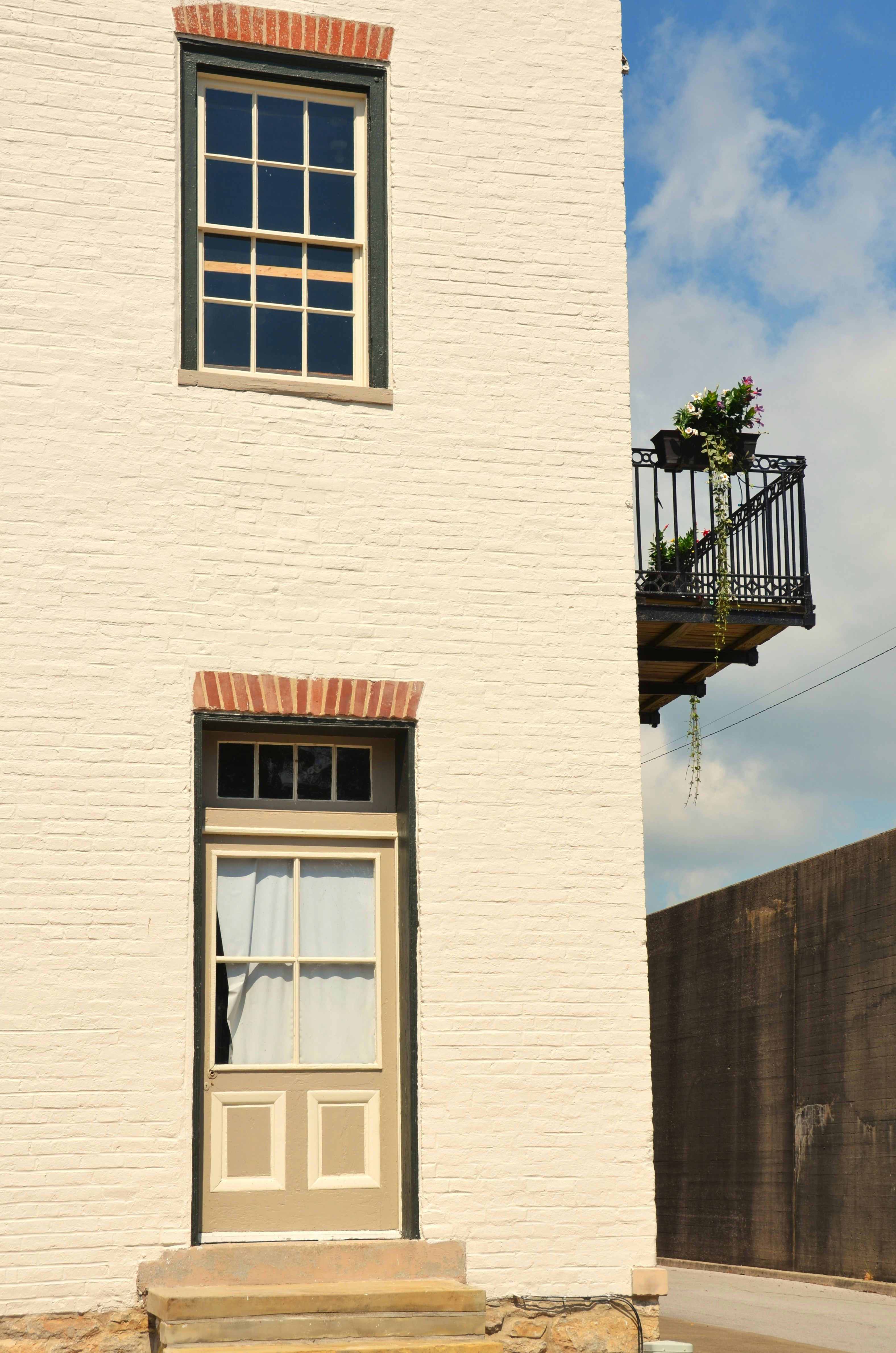 Sunlit Brick Facade with Balcony Accent