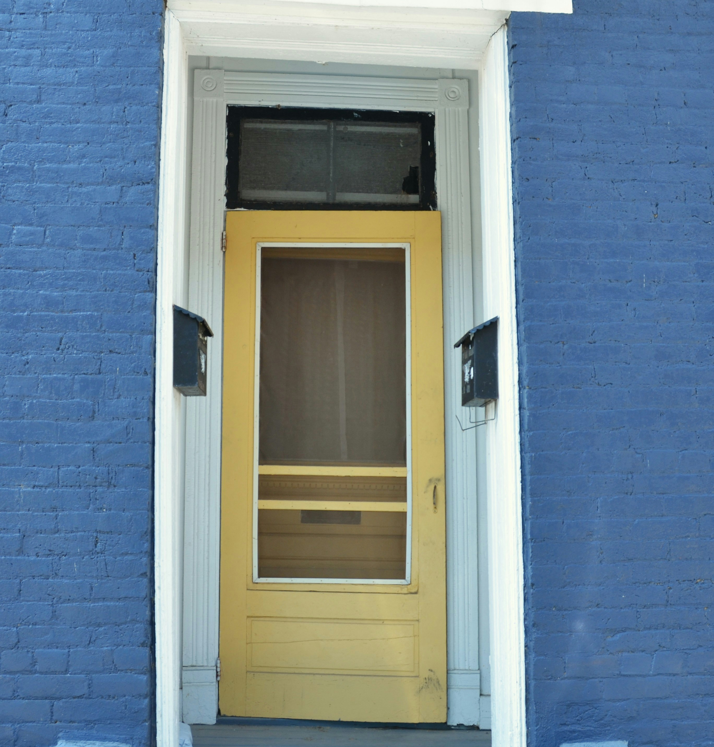 Yellow Doorway Framed by Blue Brick Wall