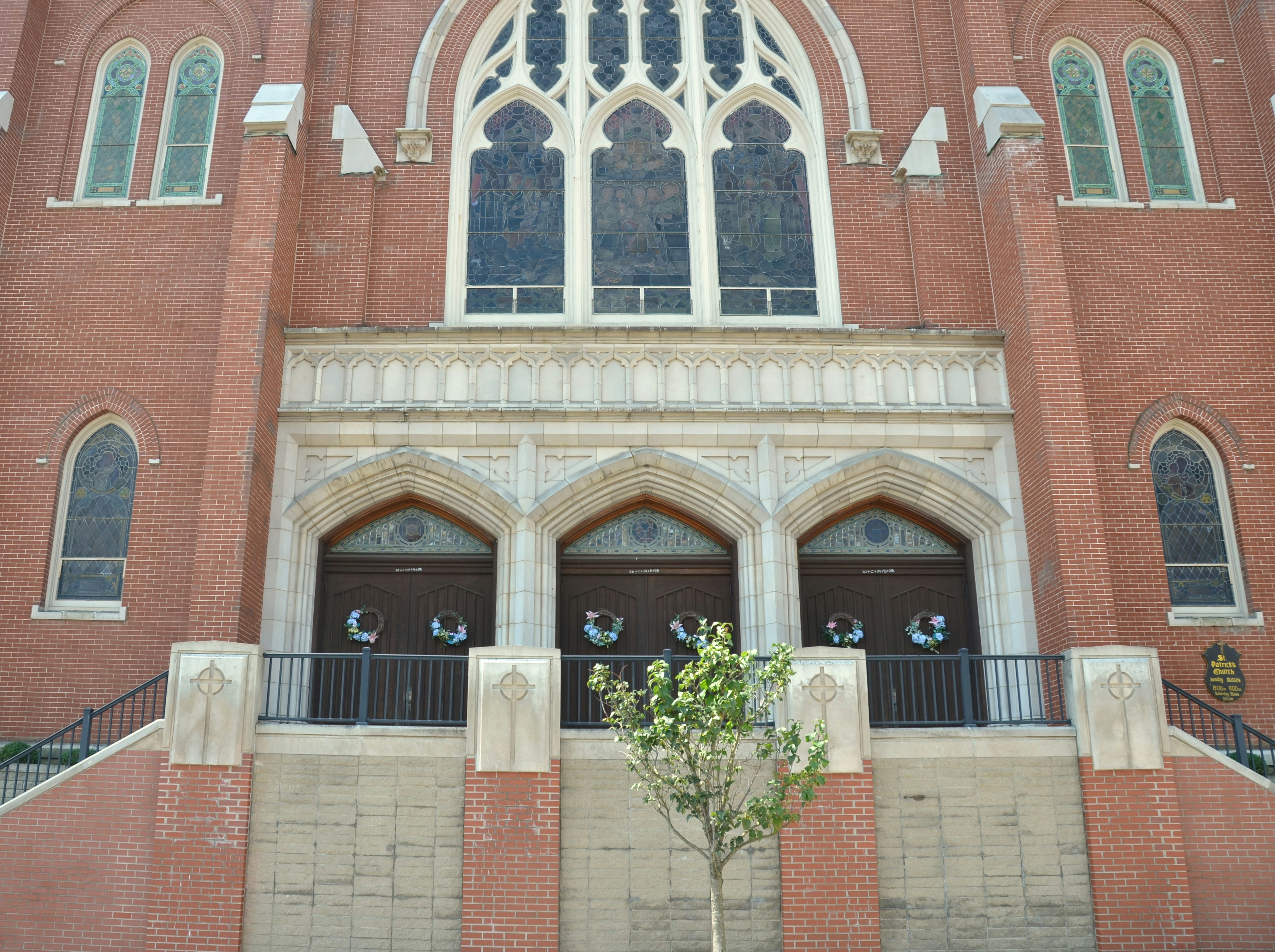 Arched Entryways Framed by Church Brickwork and a Central Sapling