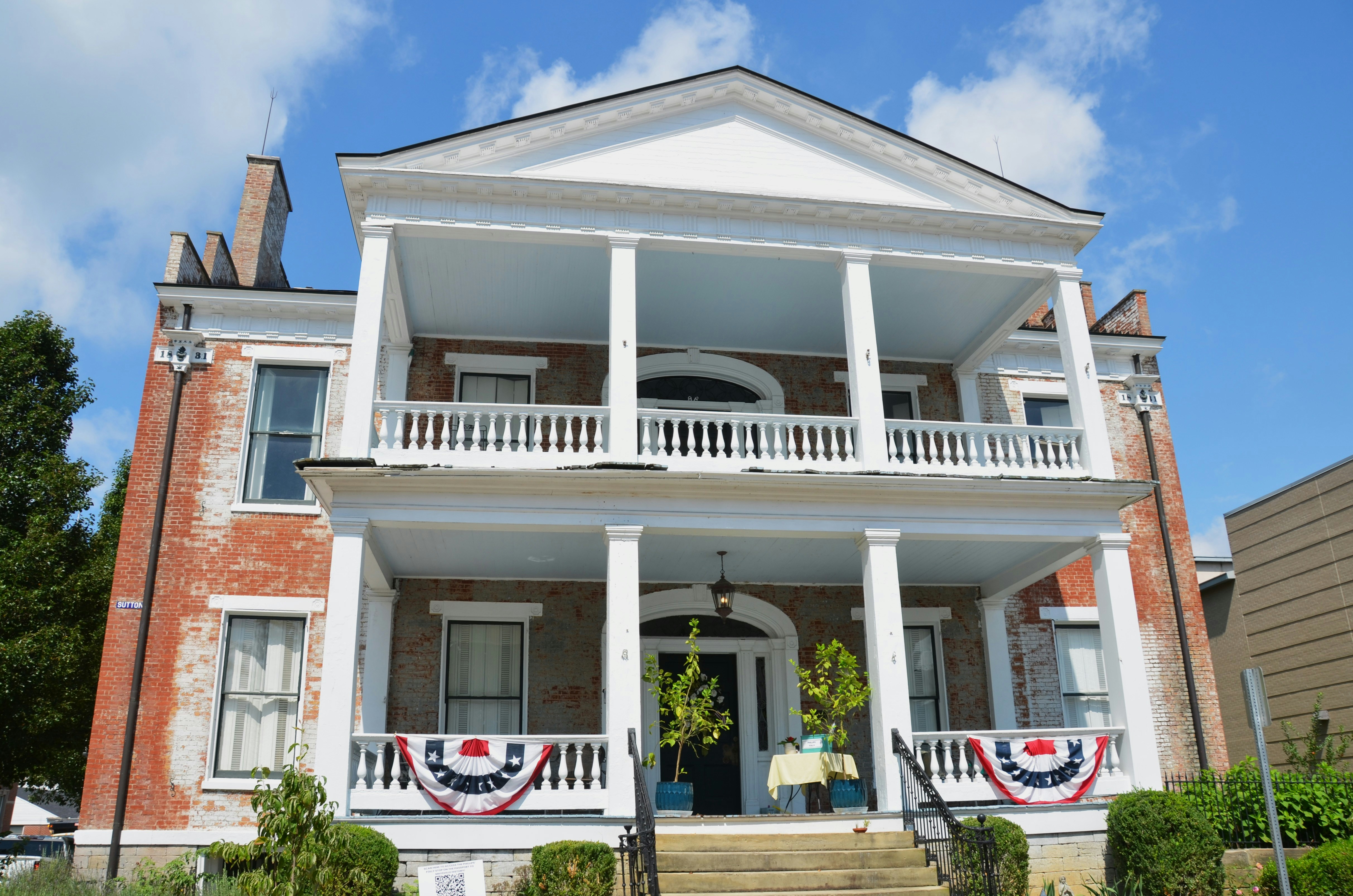 Symmetrical Victorian Home with Patriotic Banners Framing a Front Porch