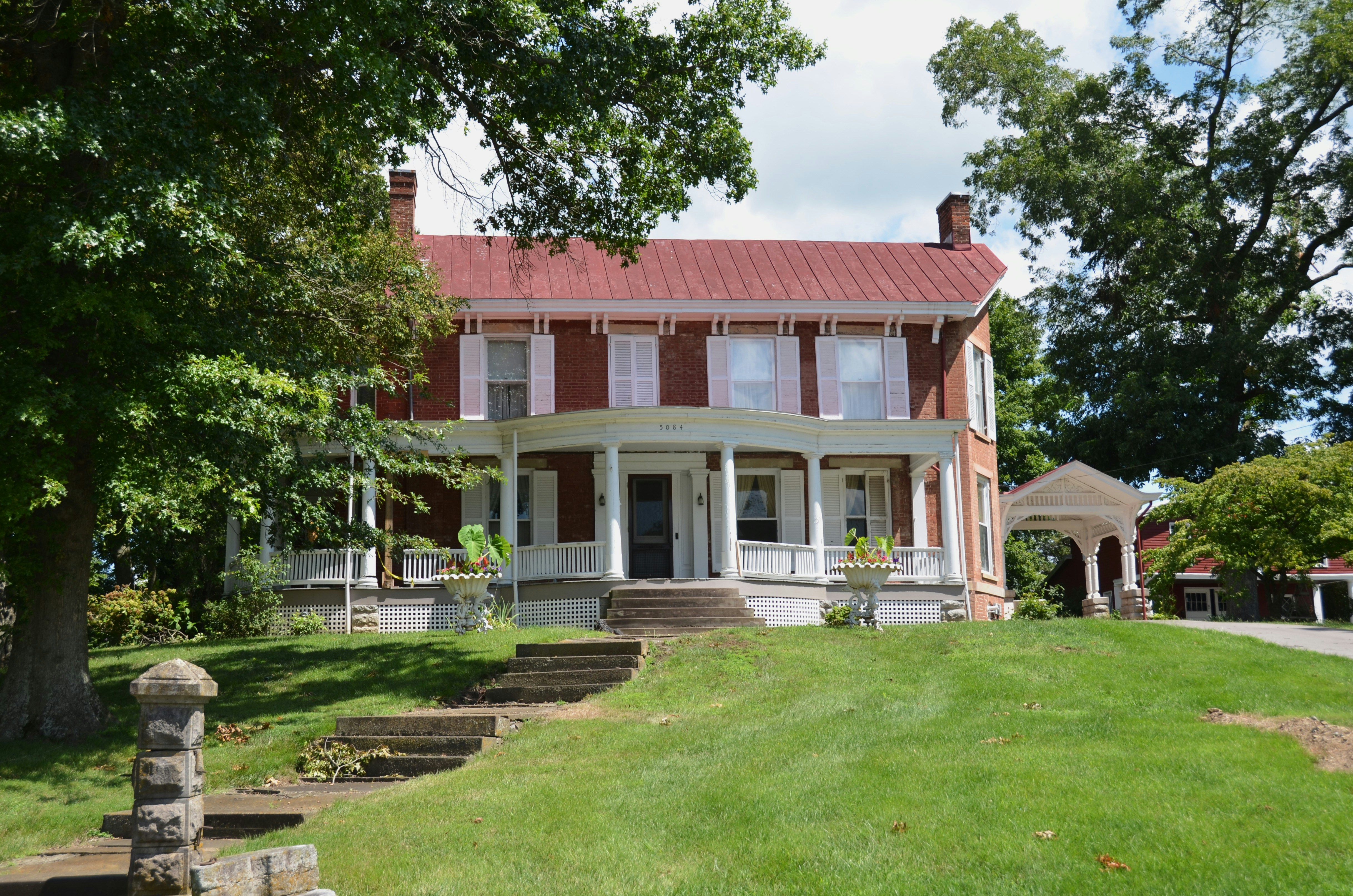 Quiet Mansion, Green Slopes: A Classic Brick Home Under Shadowed Trees