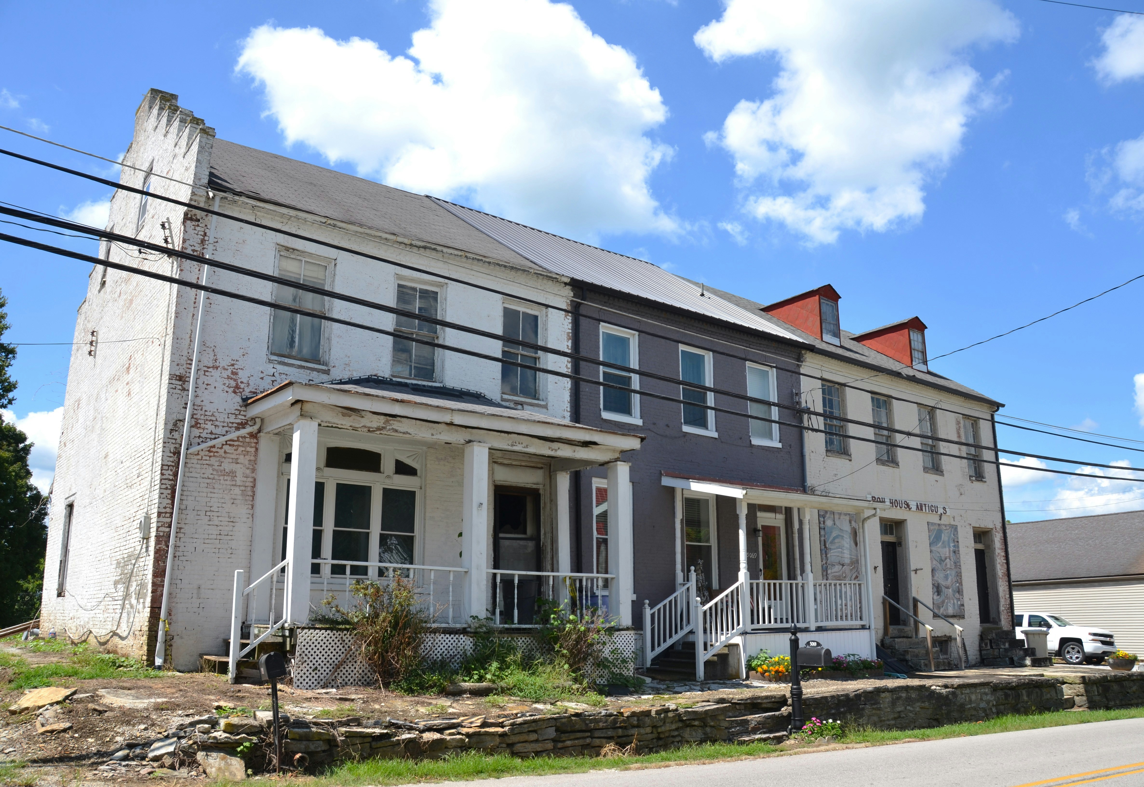 Row of weathered townhouses under a bright afternoon sky