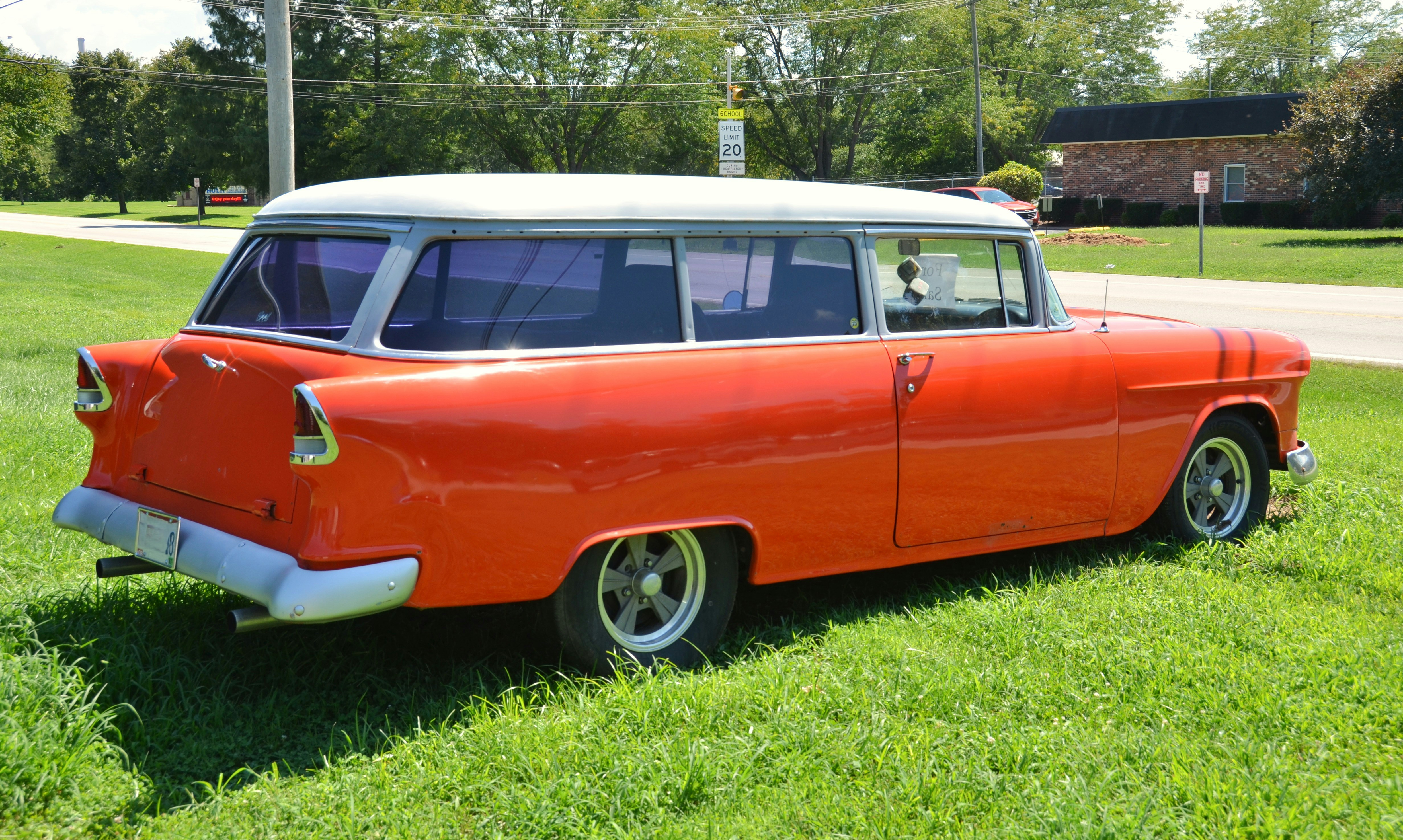Vintage Orange and White Suburban Classic Resting in Sunlit Field