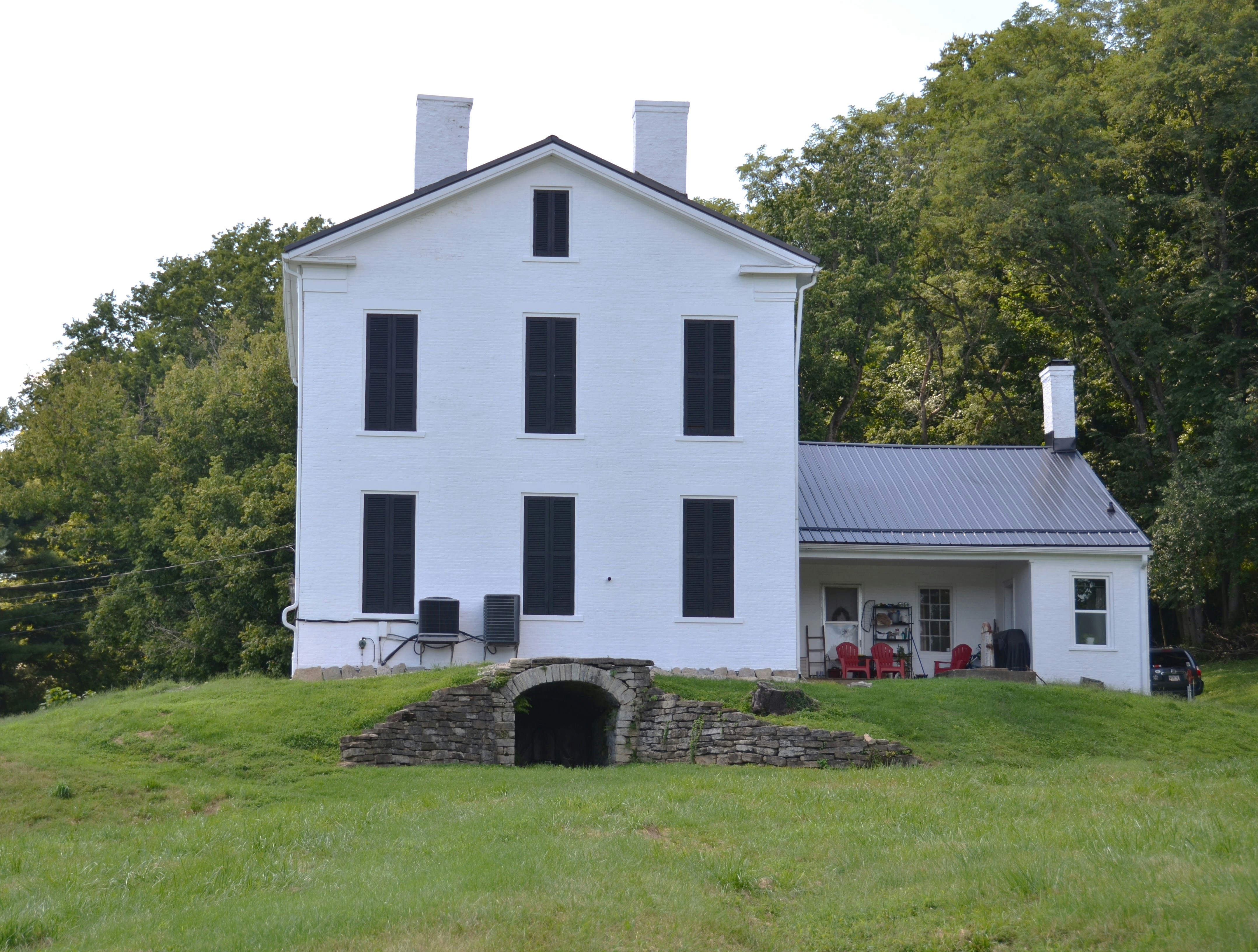 White Farmhouse on a Gentle Slope with Stone Knoll