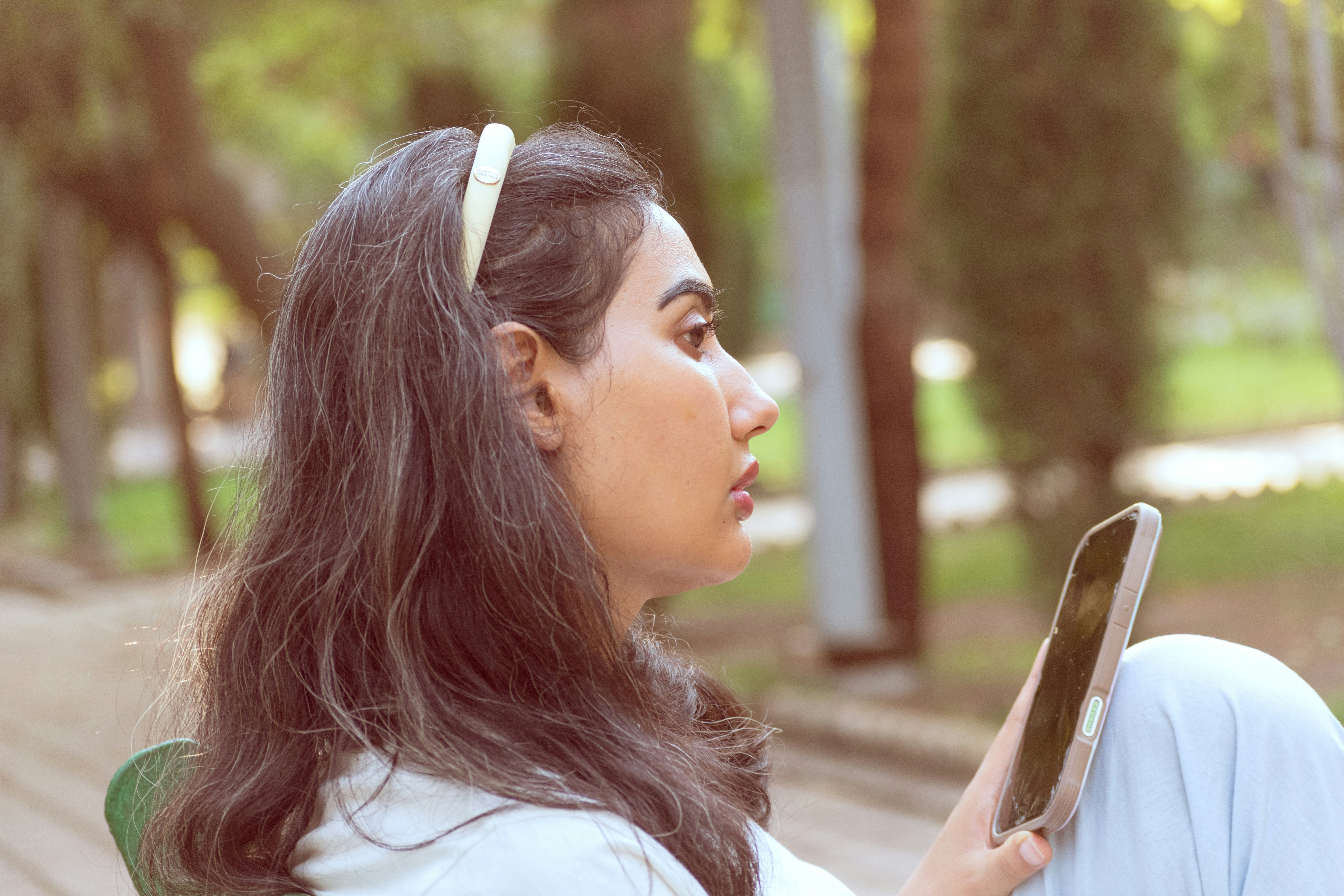 Profile in Soft Focus: A Quiet Moment with a Phone in the Park