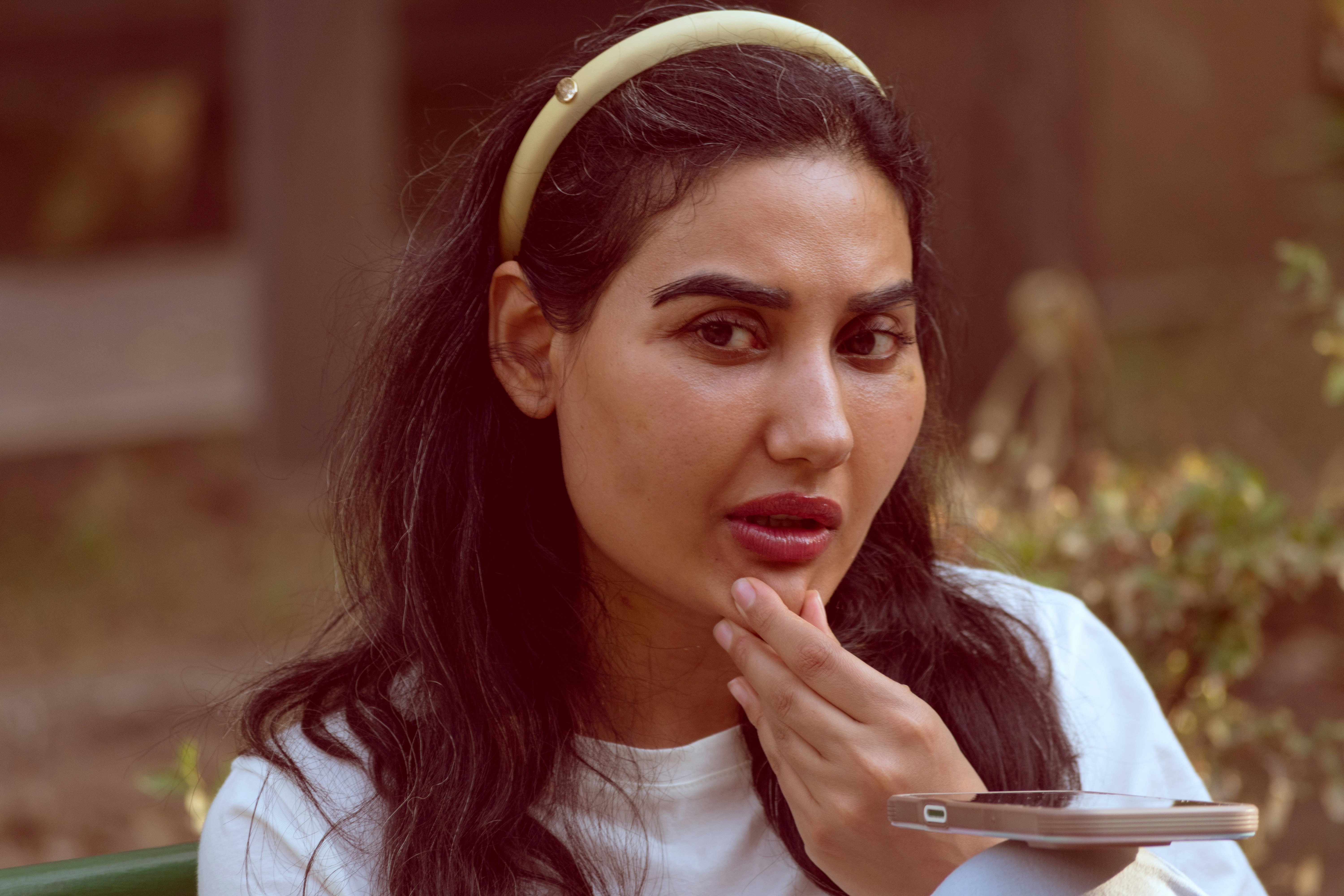 Contemplative Moment: A Woman with a Phone Pauses in Soft Light