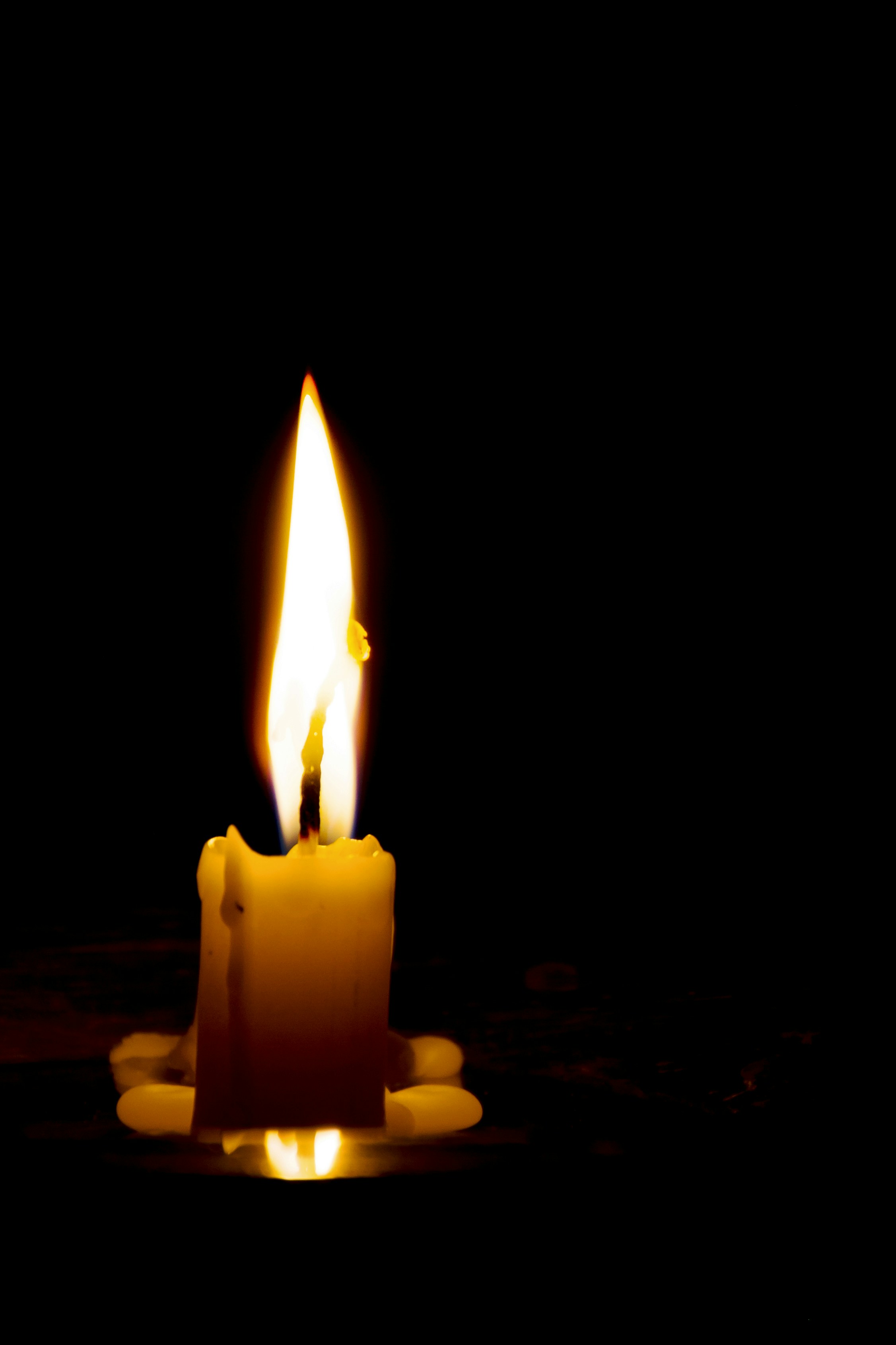 Single Candle Flame: Quiet Intensity in a Black Backdrop