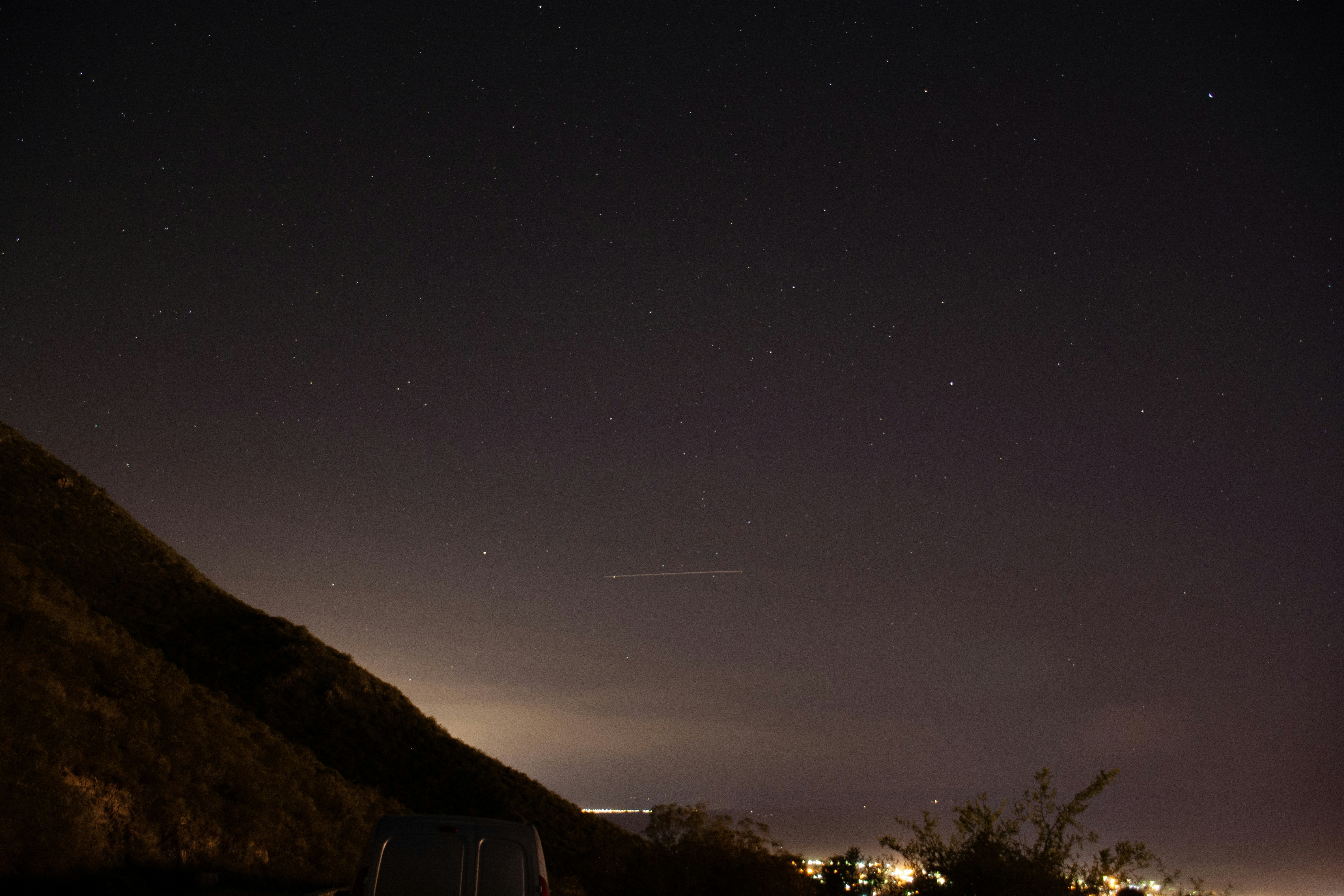 Night-sky glow over a quiet hillside valley