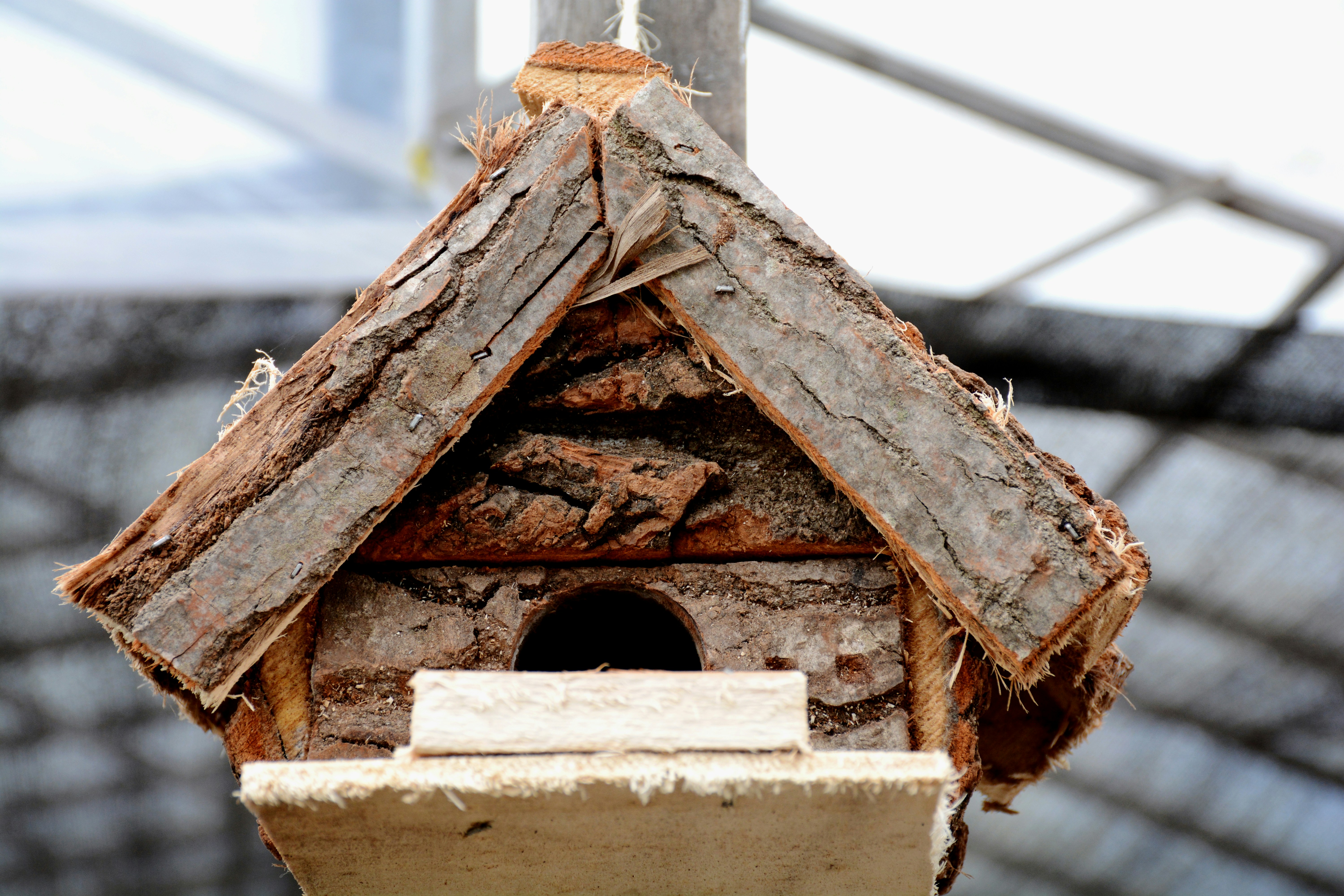 A Weathered Birdhouse Under Soft Overhead Light