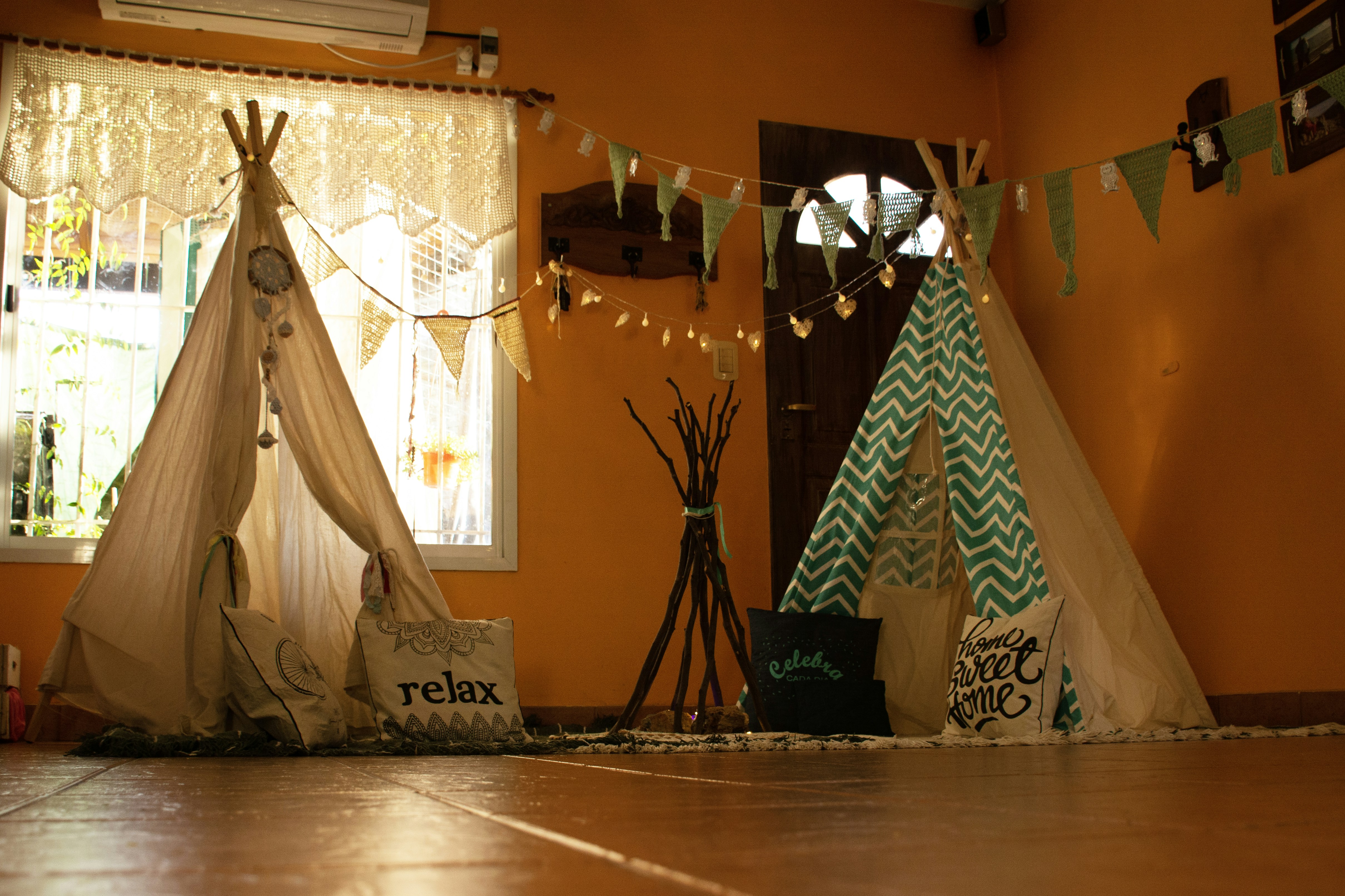 Warm Corner Camp: Colorful Teepees and Cozy Cushions in a Sunlit Room