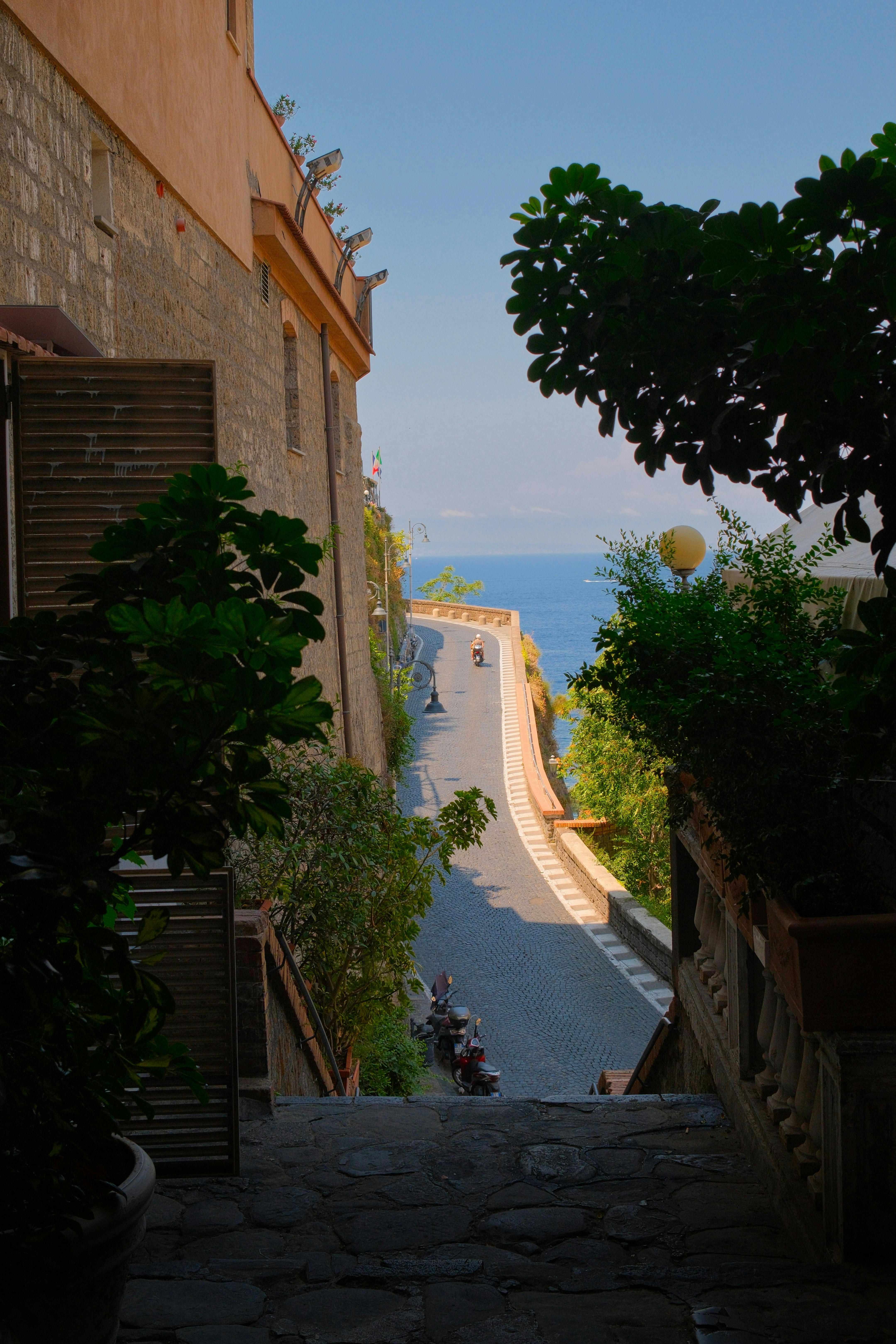 Sunlit Sea Staircase: A Coastal Passage Framed by Shadowed Courtyard