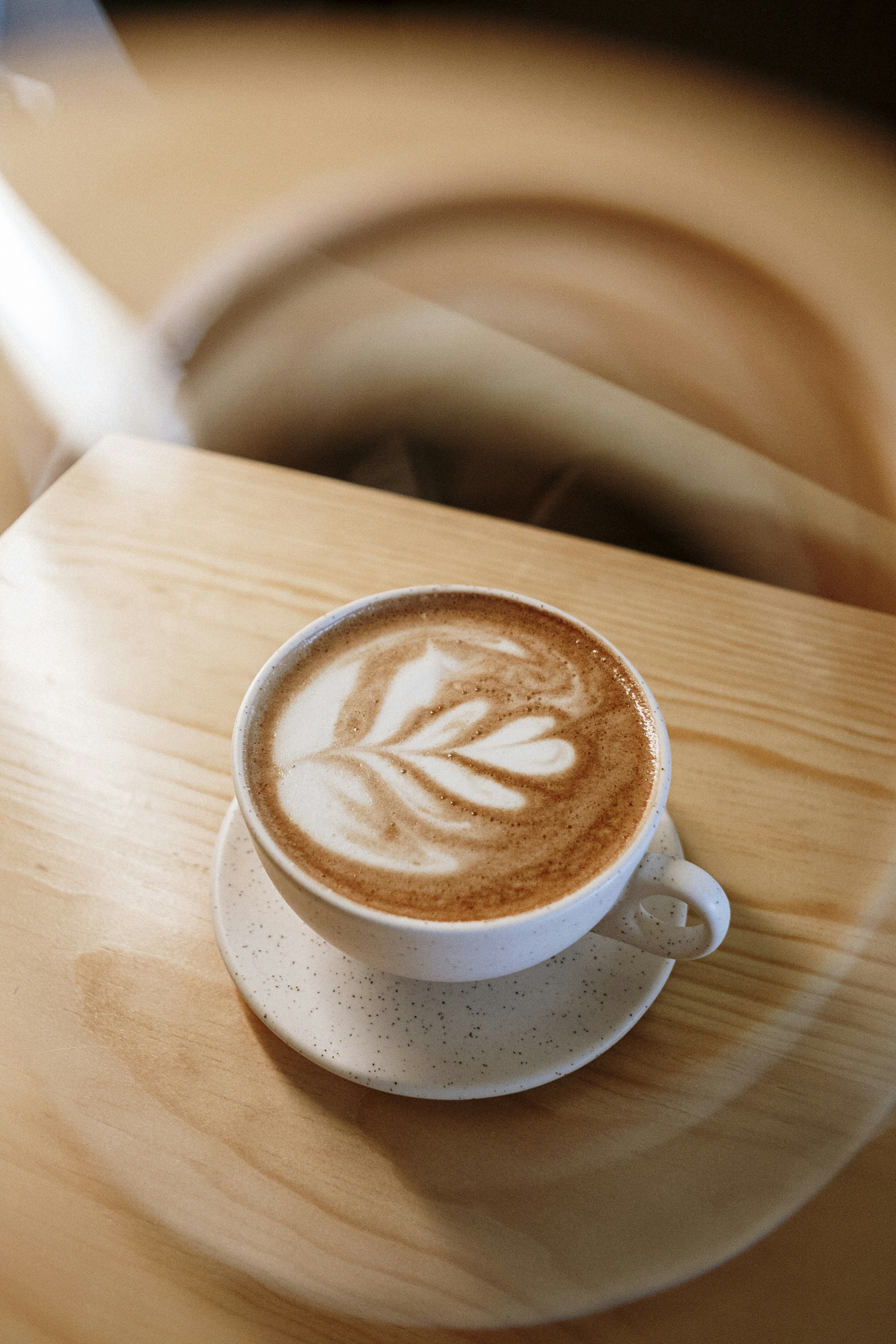 Steamed Canvas: Latte Rosetta on a Sunlit Wood Table