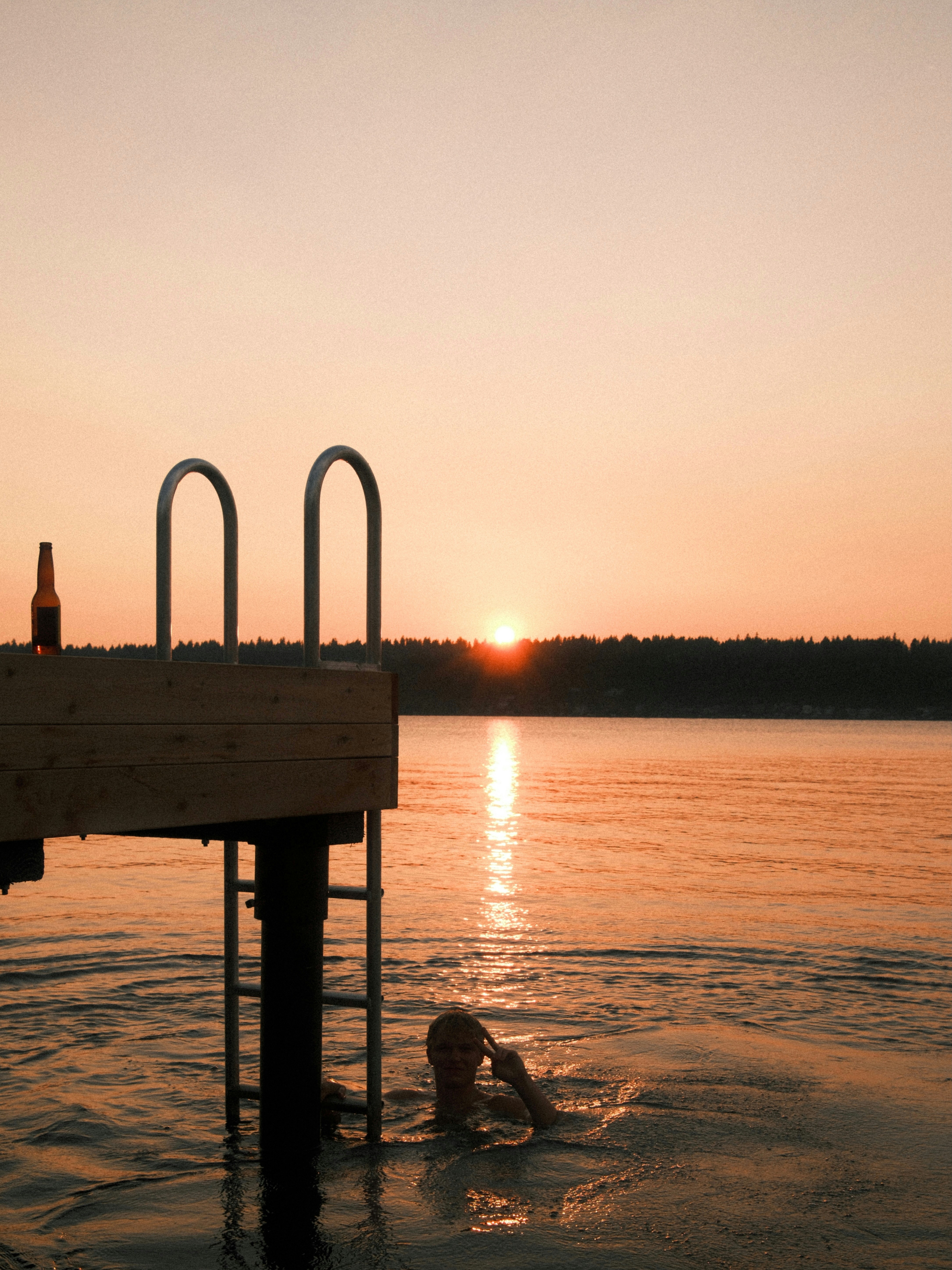 Sunlit Exit: Quiet Swim by the Pier at Dusk