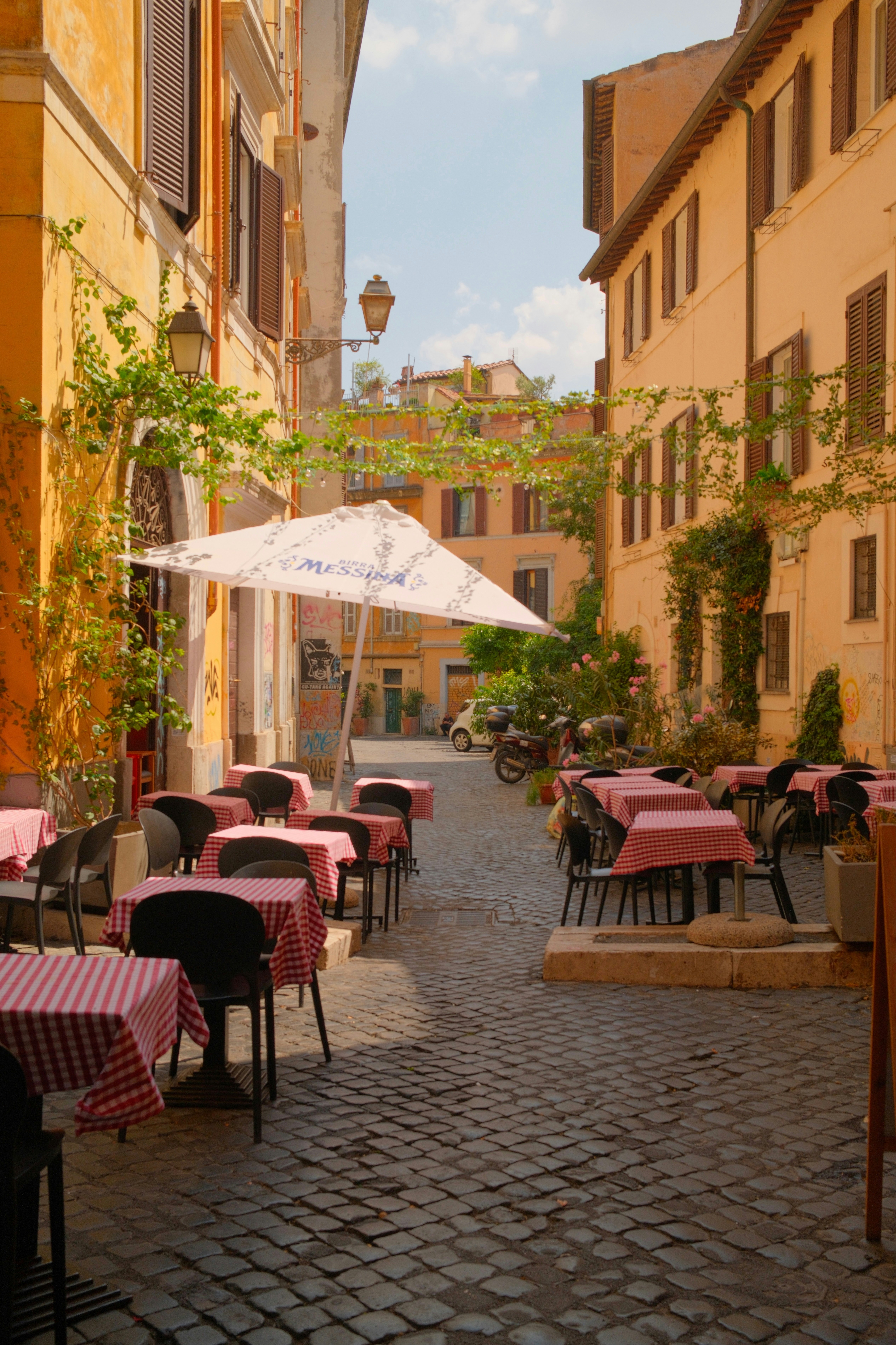 Sunlit Terrace on a Shaded Italian Lane