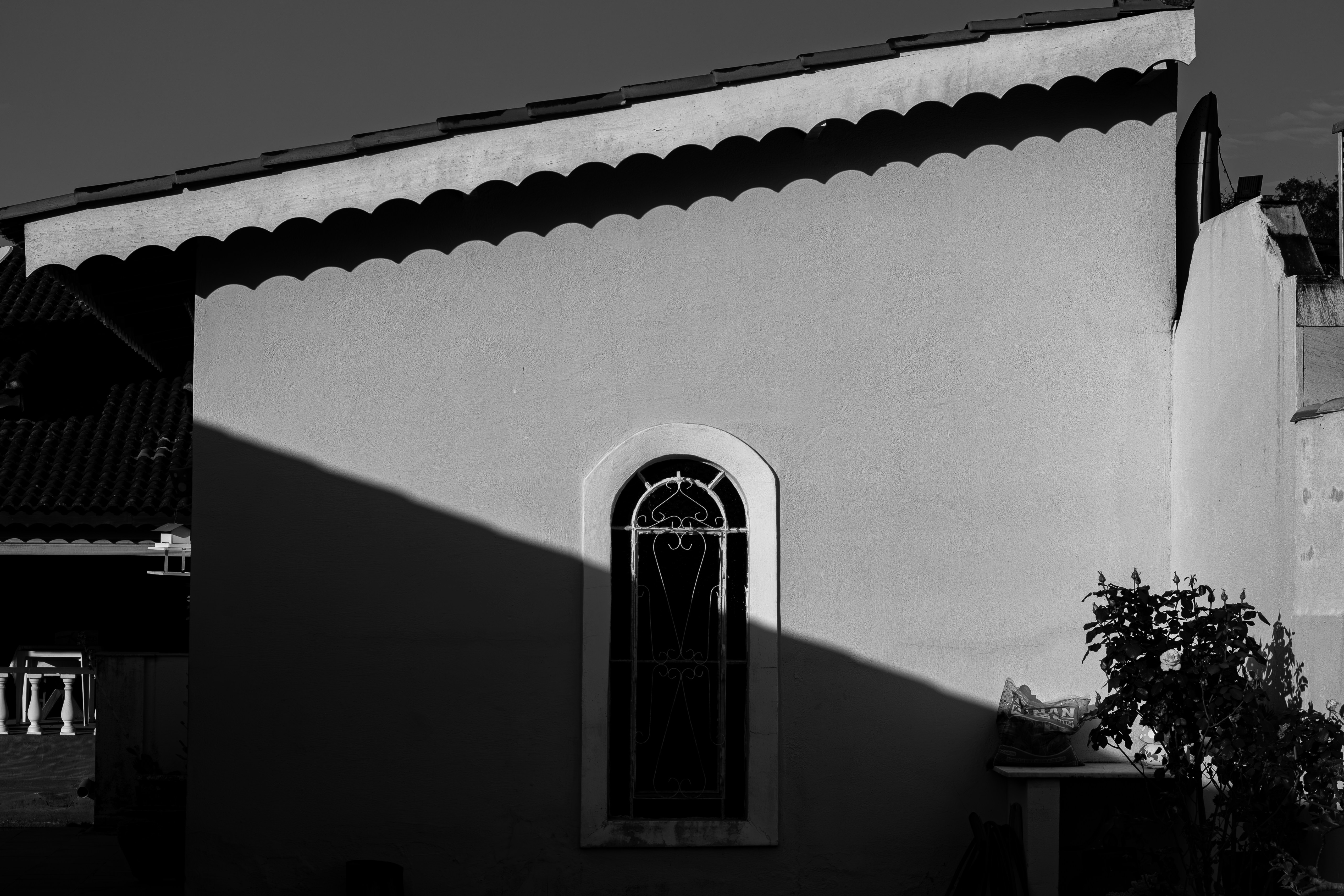 Shadowed Facade Under a Scalloped Roofline