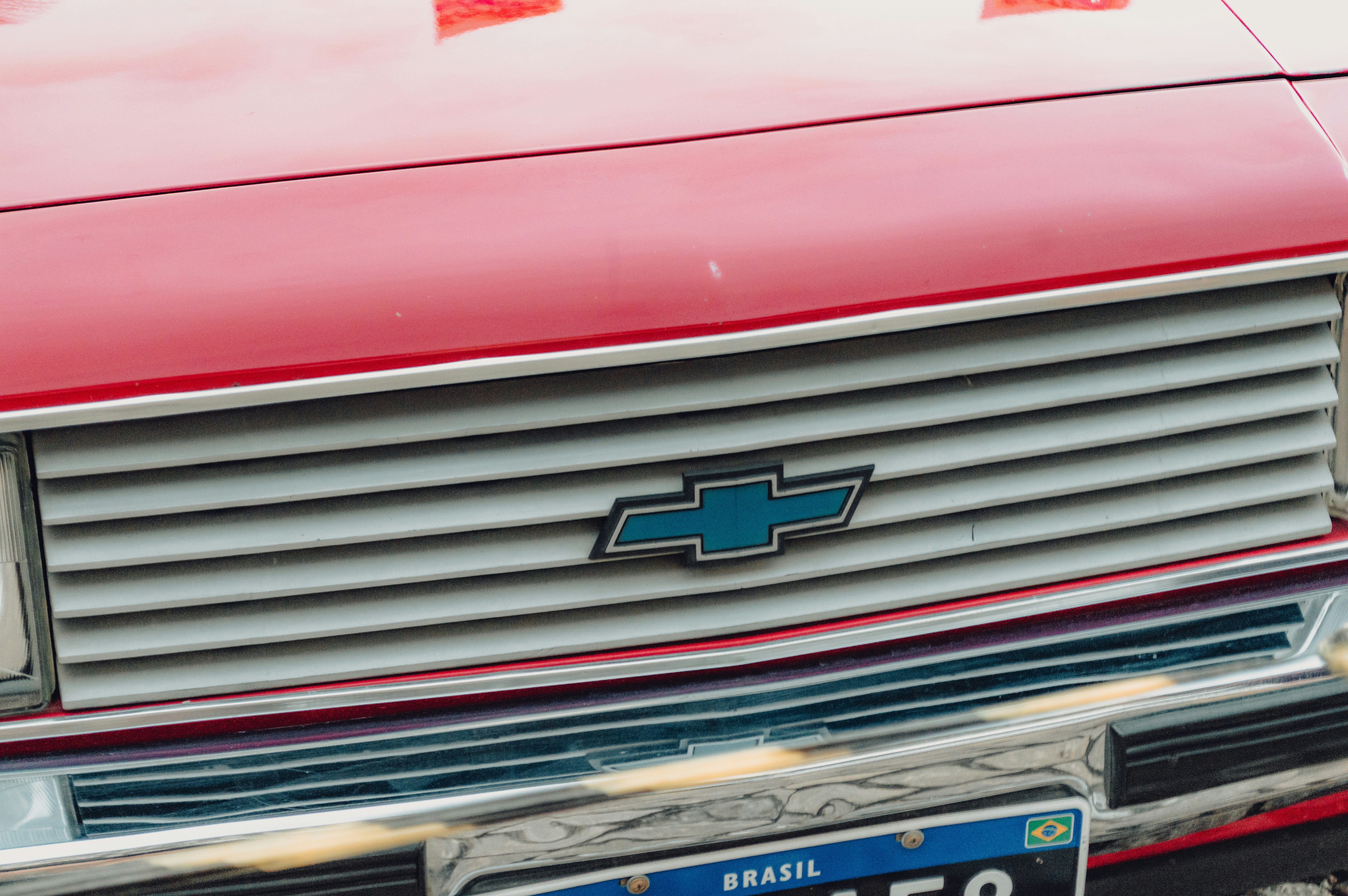Emblem in Focus: The Chevrolet Grille and Crest on a Red Pickup