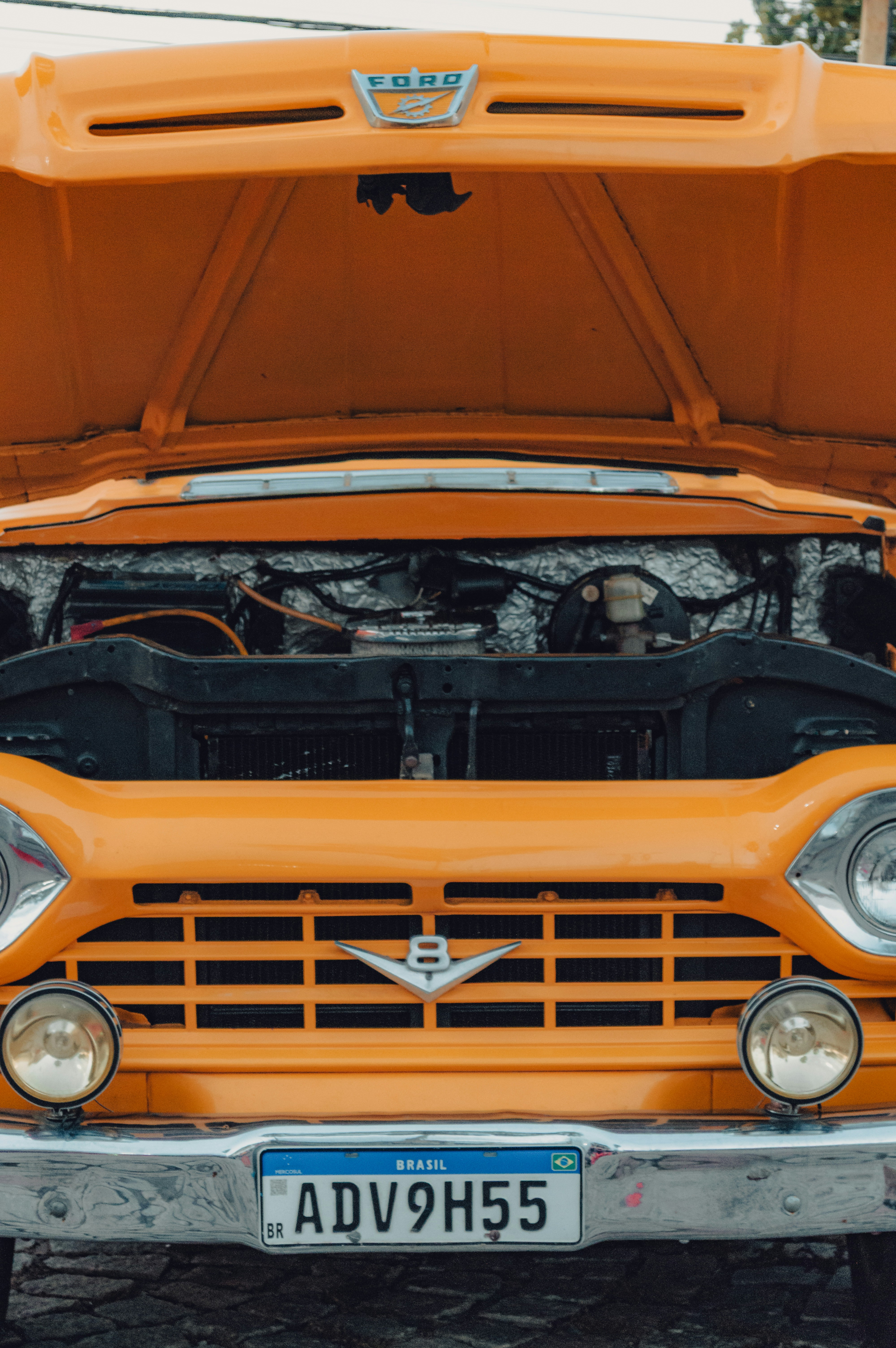 Open Hood, Vintage Ford in Waiting: A Bold Orange Stare into the Engine Bay