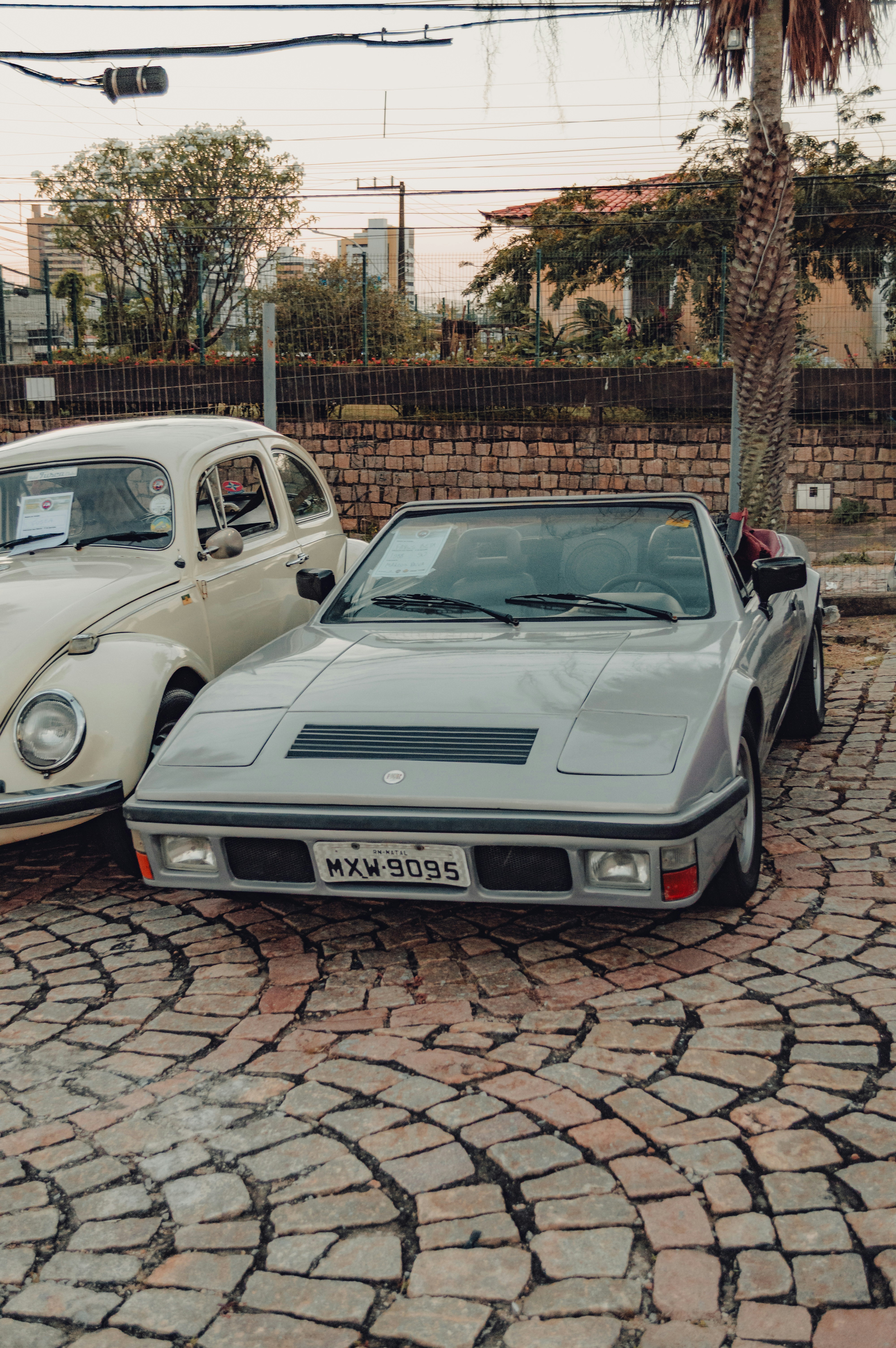 Silver Ferrari-Like Dream: A Porsche-Topped Close-Up in a Cobblestone Lot