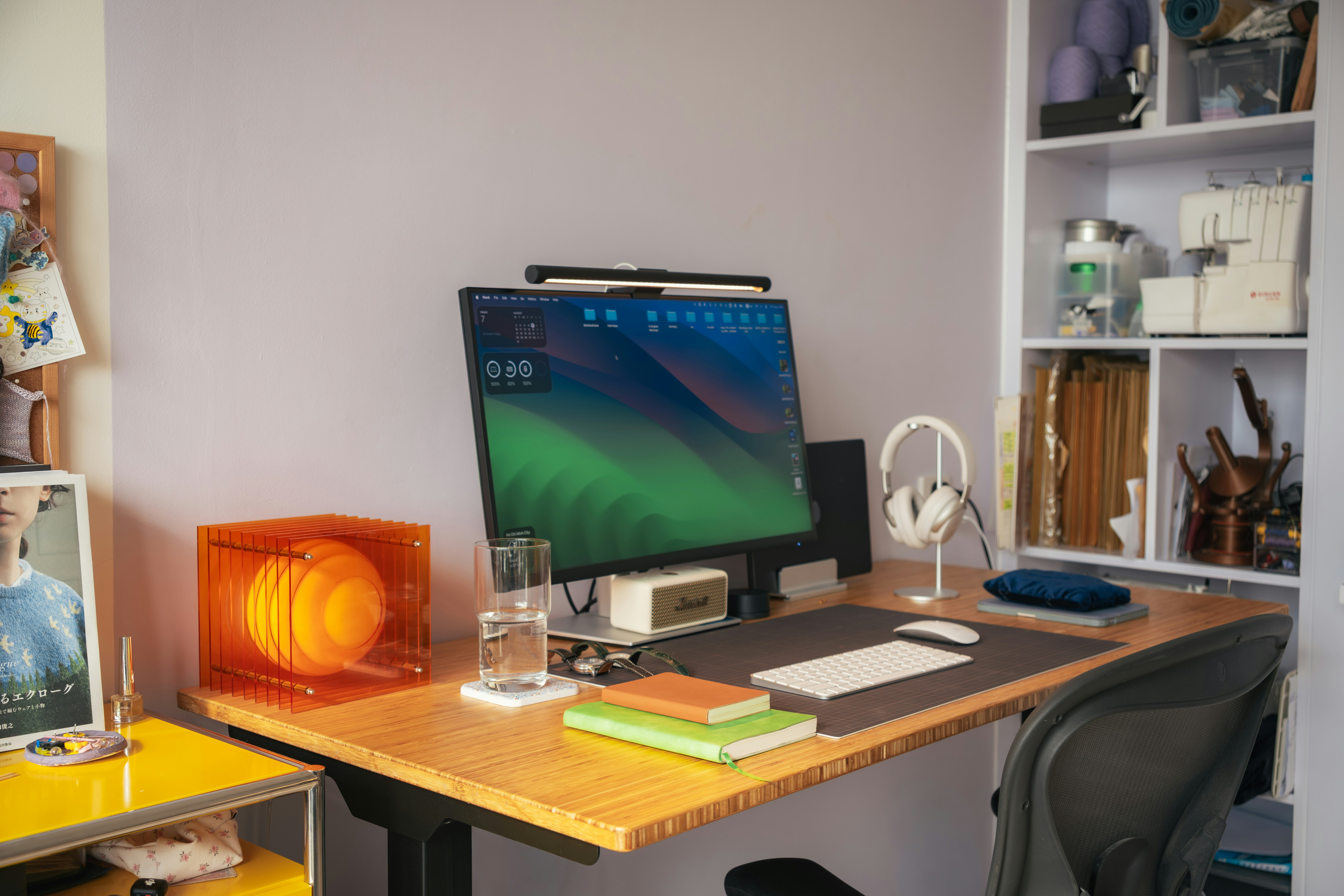 A tidy creator’s desk with a vibrant monitor and warm glow