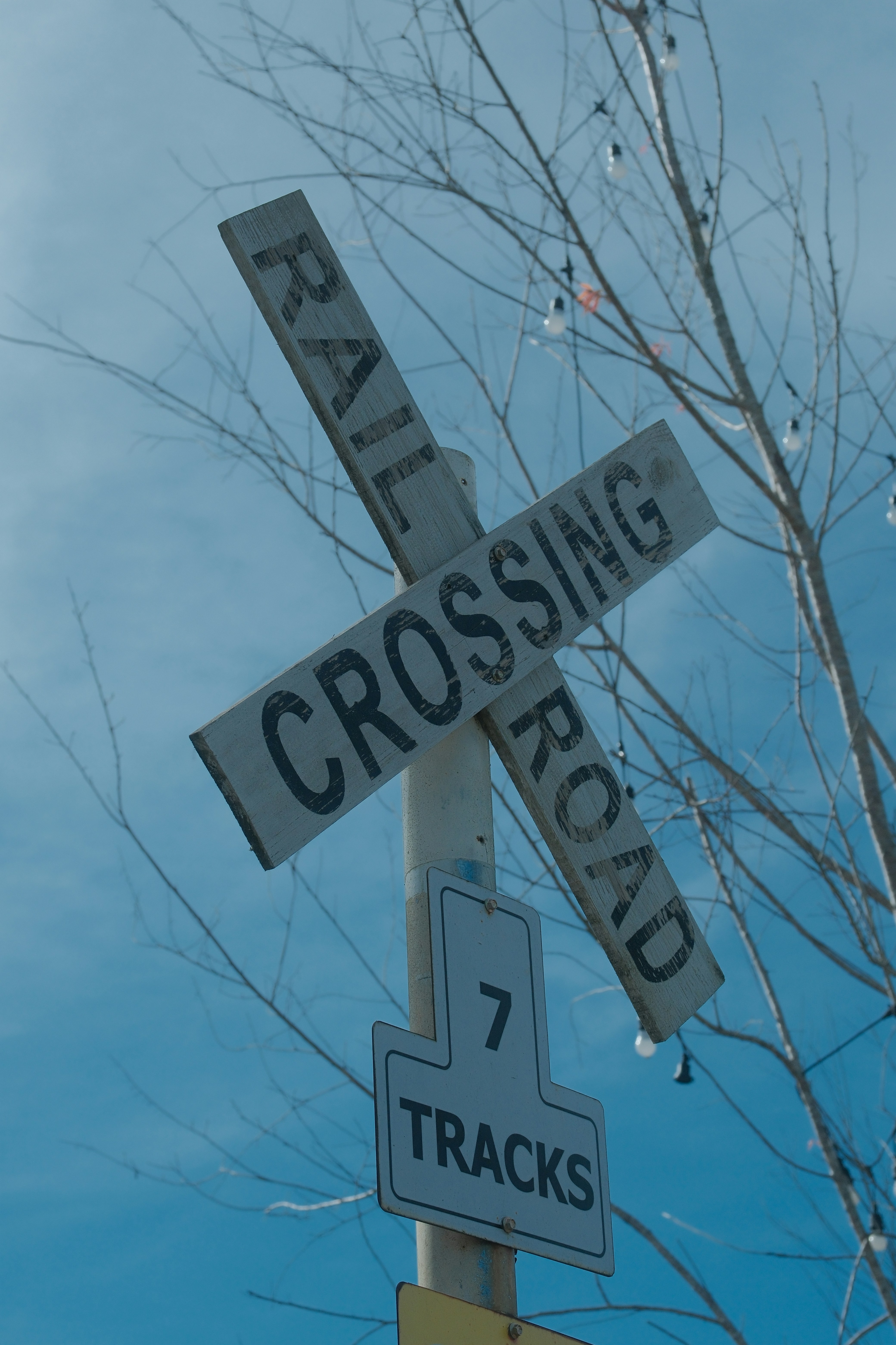 Crossing Rails: Tracks Signage Under a Clear Sky