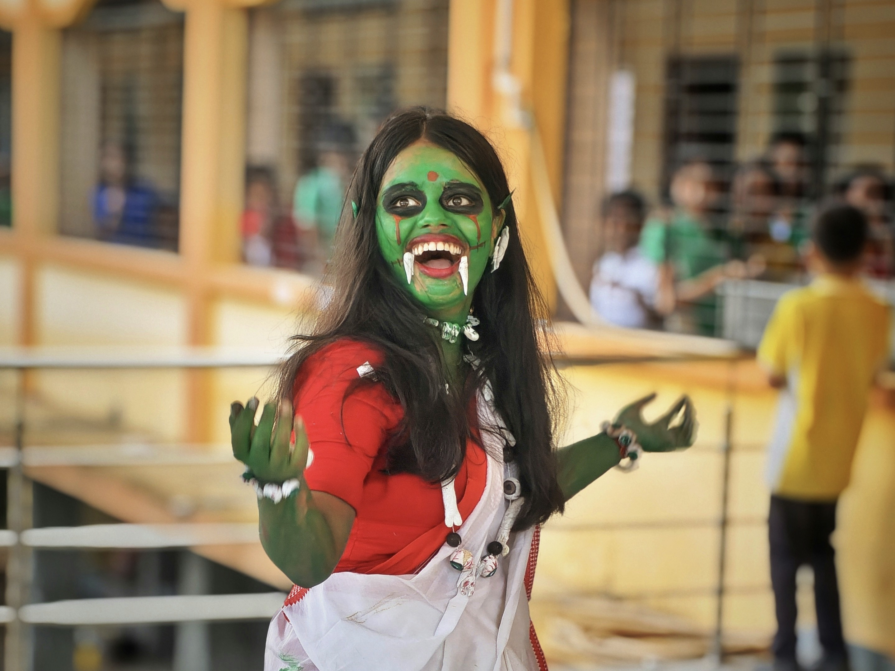 Green-faced performer in festive attire greets a lively crowd