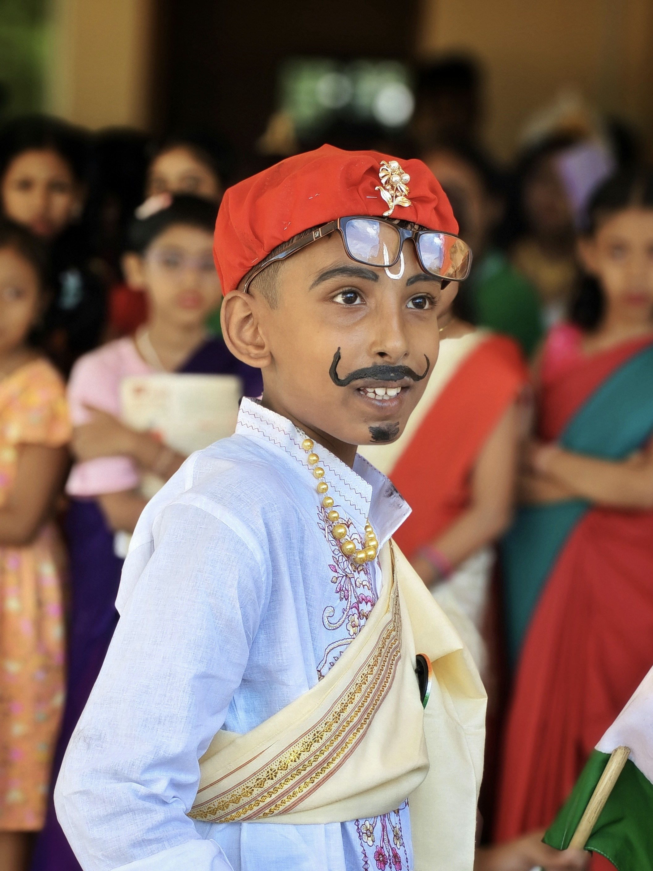 Young Dancer with Red Turban: A Festive Portrait in Colorful Crowd