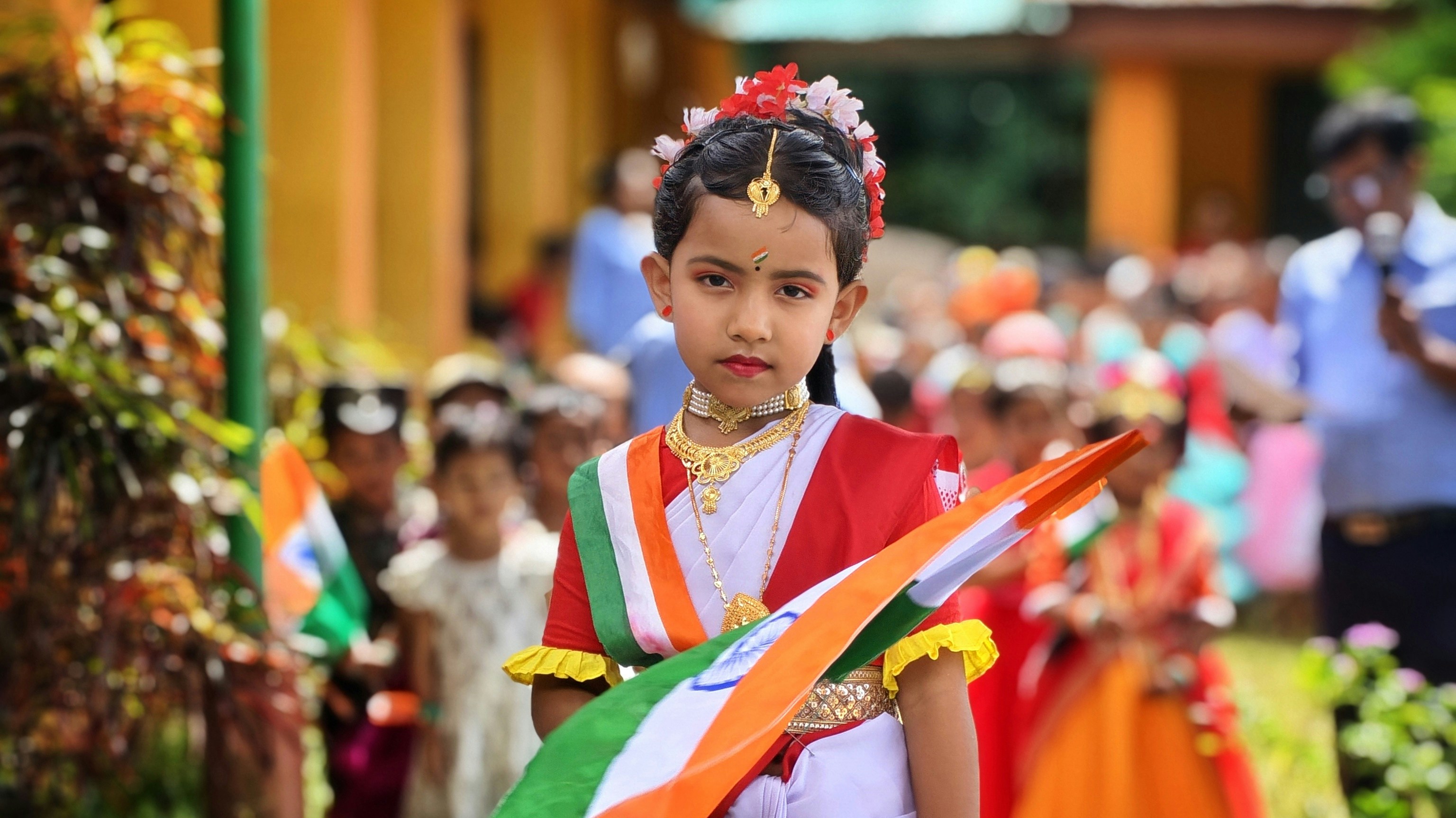 Young dancer in festive Indian attire poised at a colorful procession