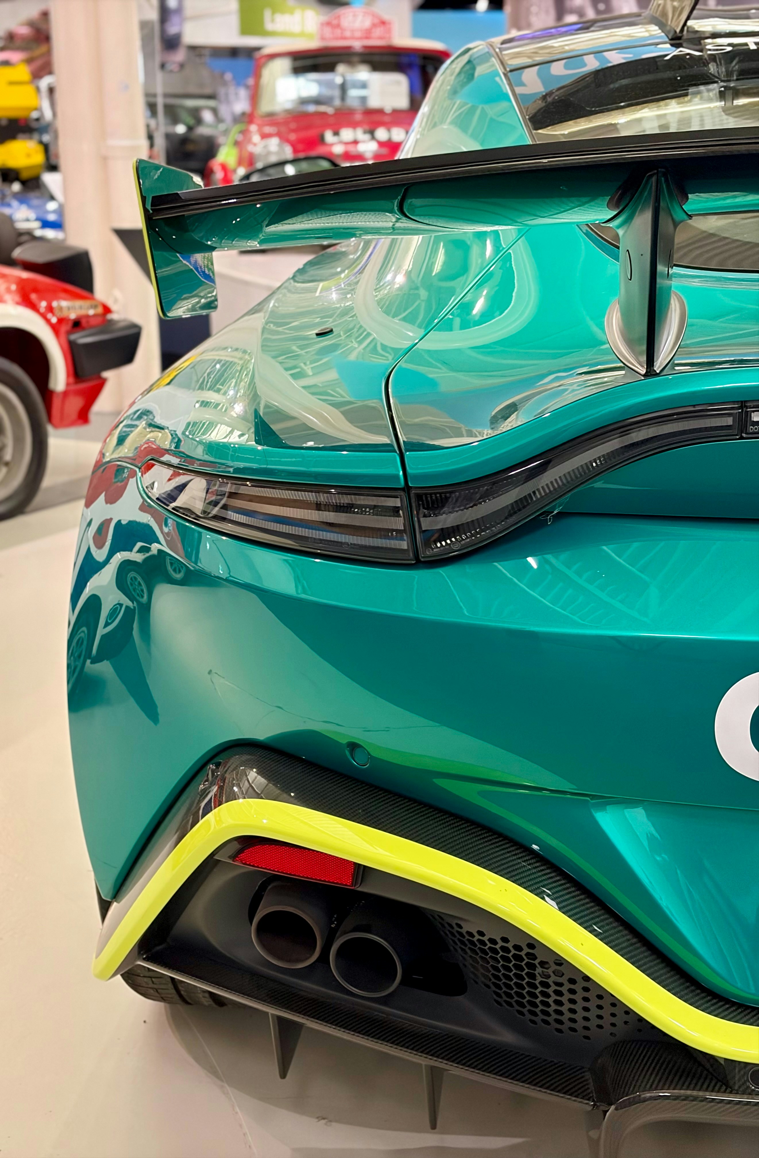 Vibrant teal rear-end of a high-performance sports car on display