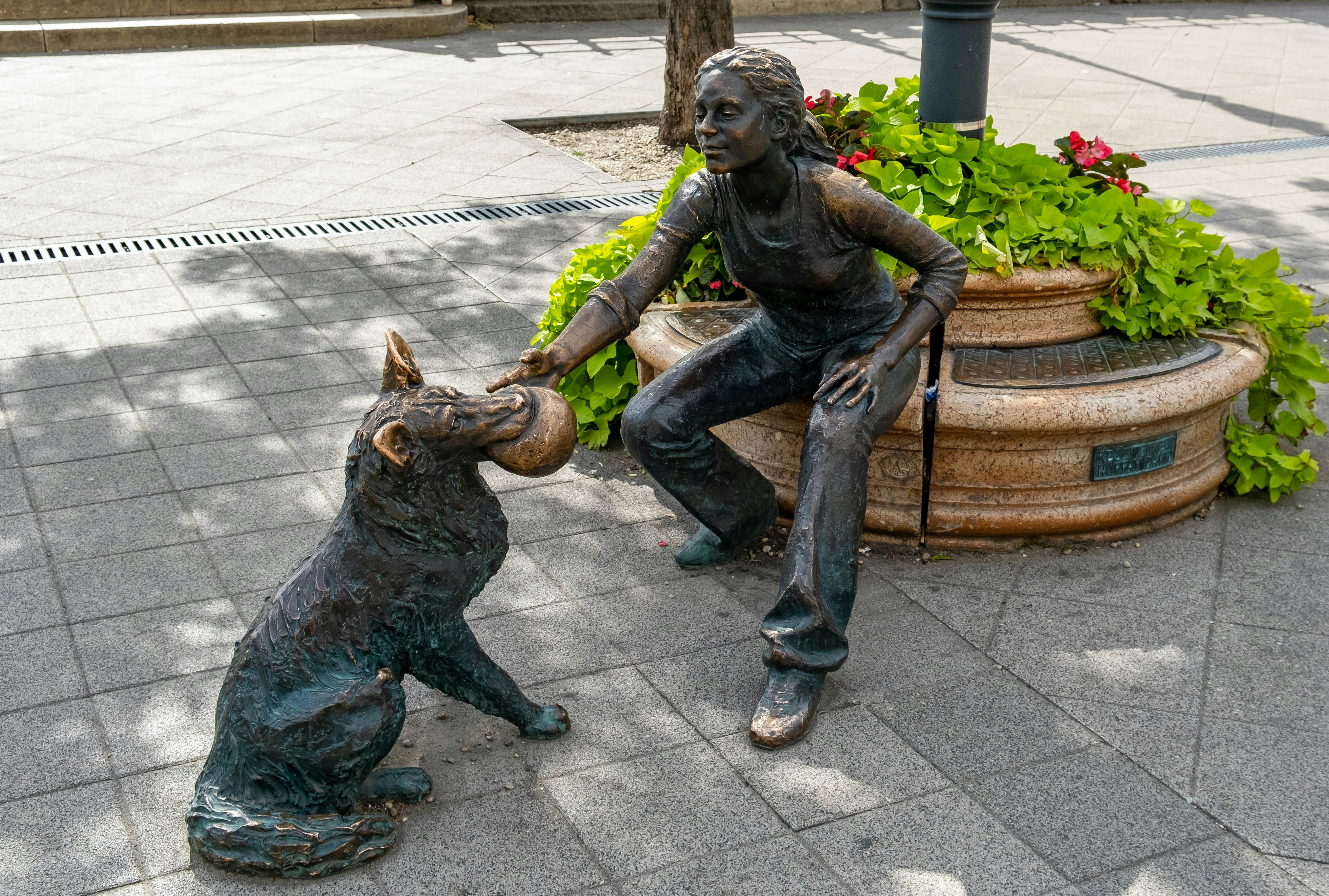Playful Encounter: A Girl Reaches to a Sculpted Dog