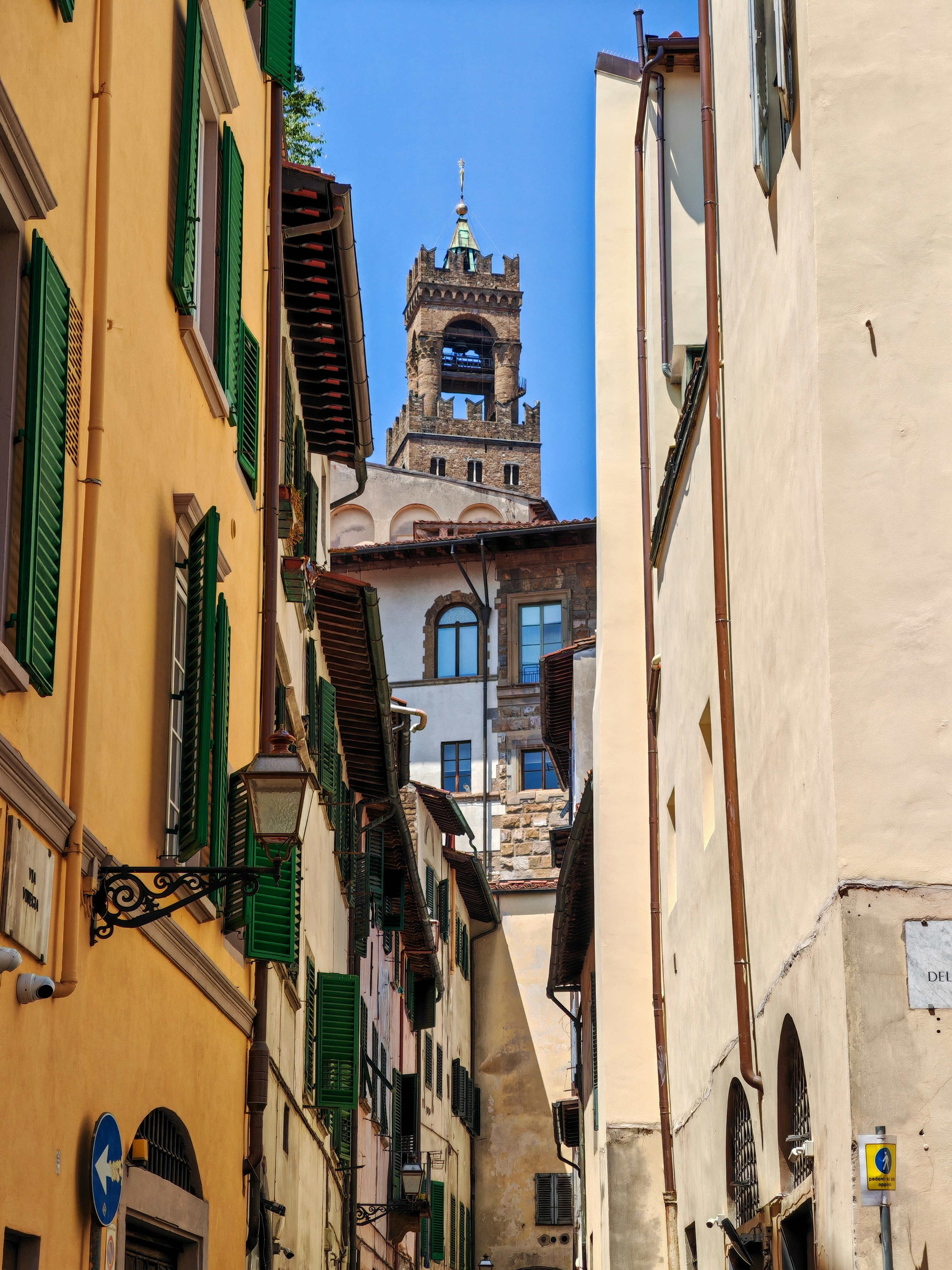 Cobbled Street Framed by Colorful Facades Leading to a Clock Tower