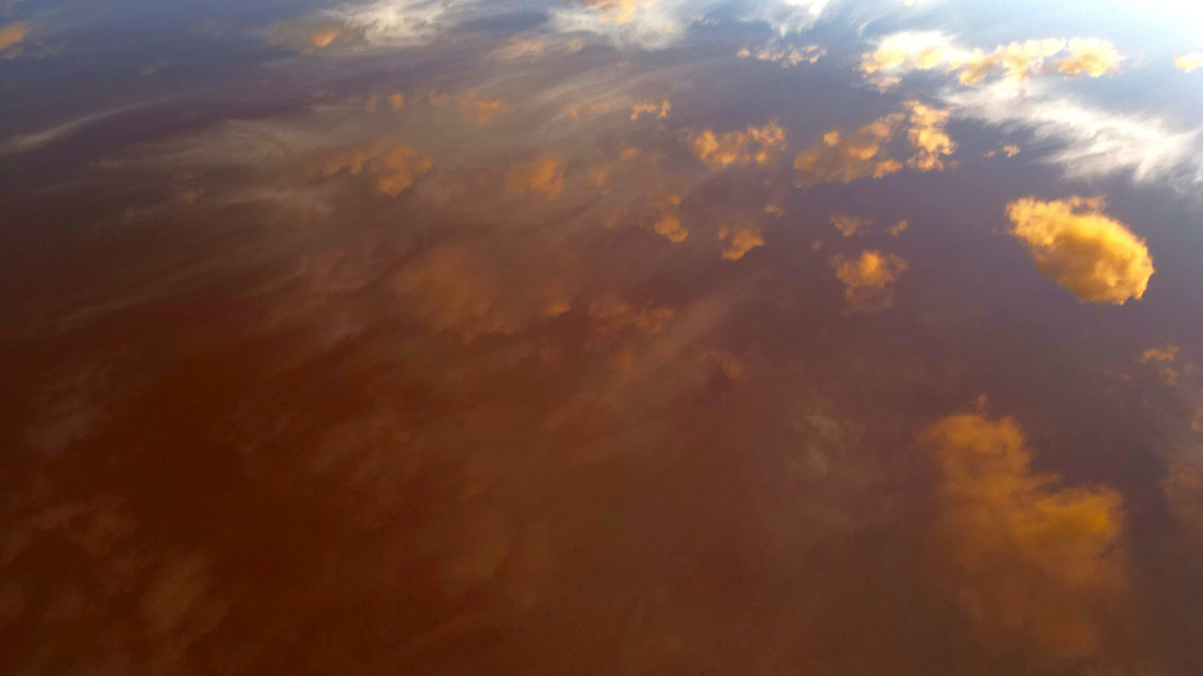Above the Calm: Cloudscape Drift over Sunset-Glowed Waters
