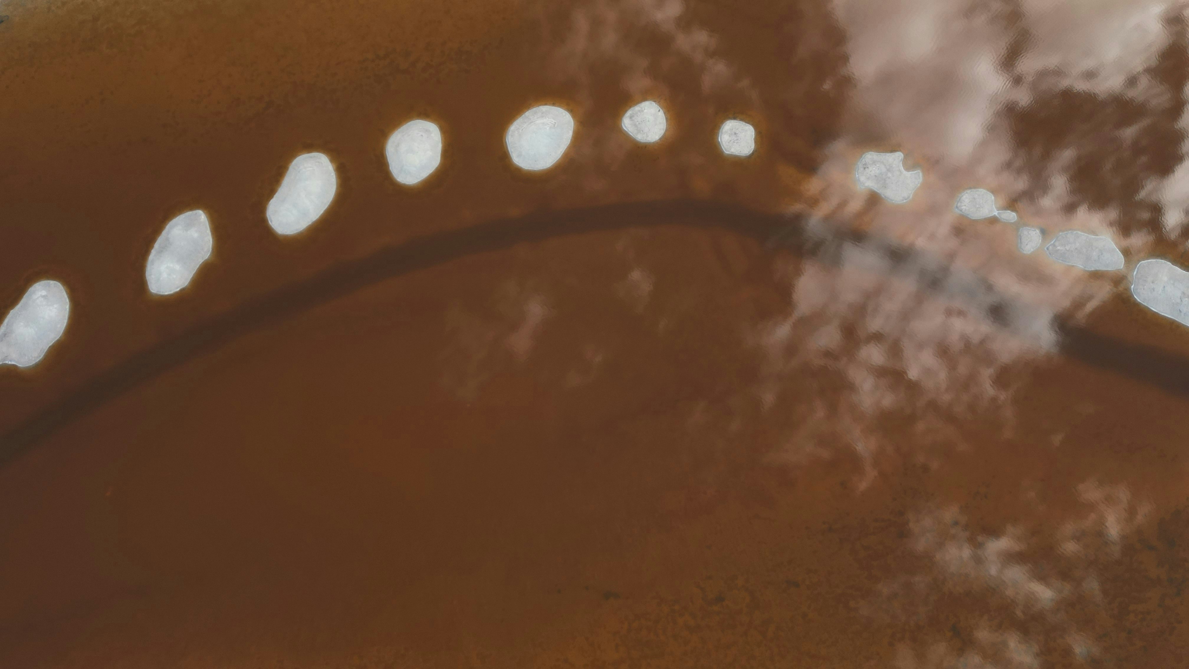 Curved Beacon: Distant Light Ring Beneath Clouds