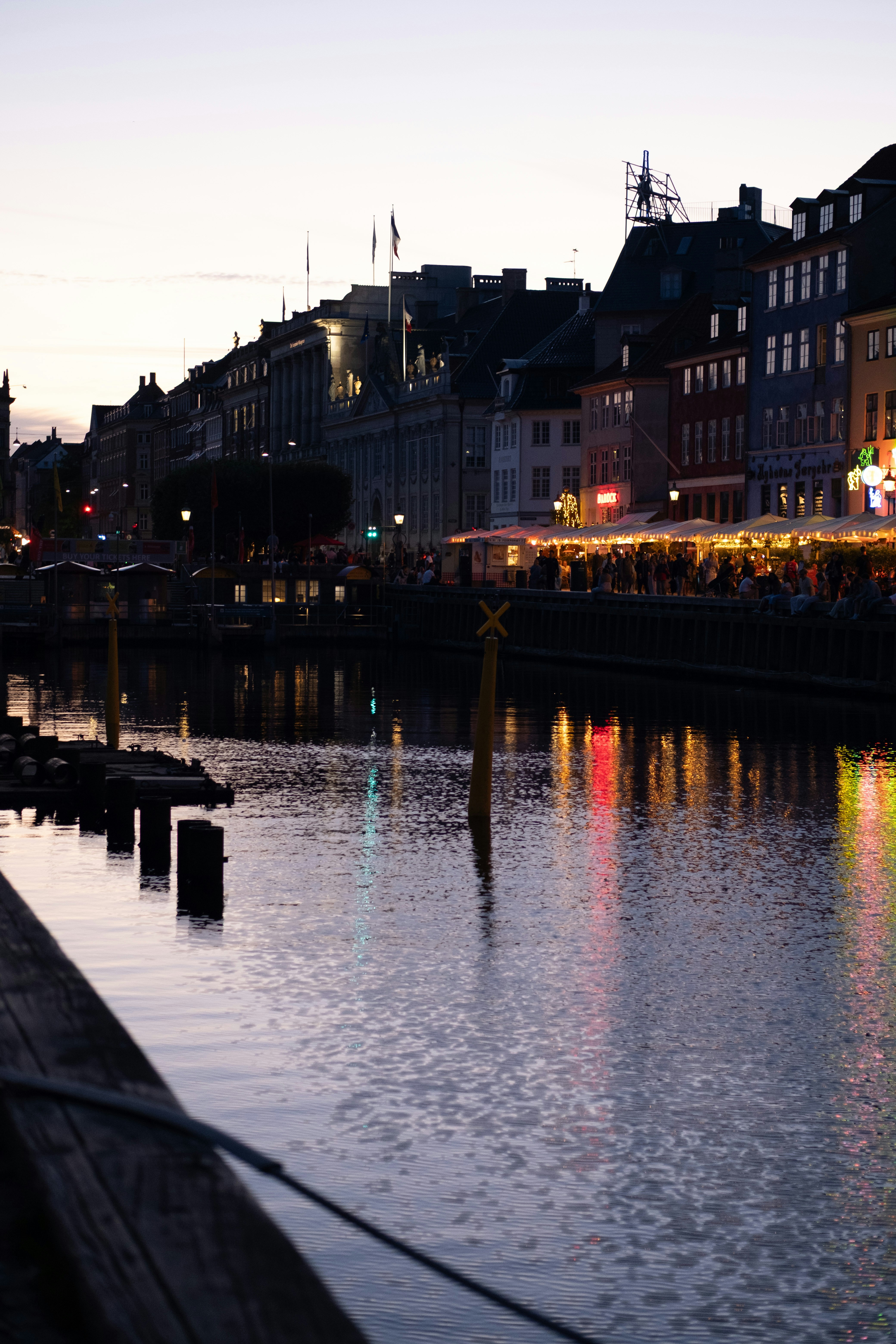 Dusk along the Urban Canal: Reflections and Neon Glow