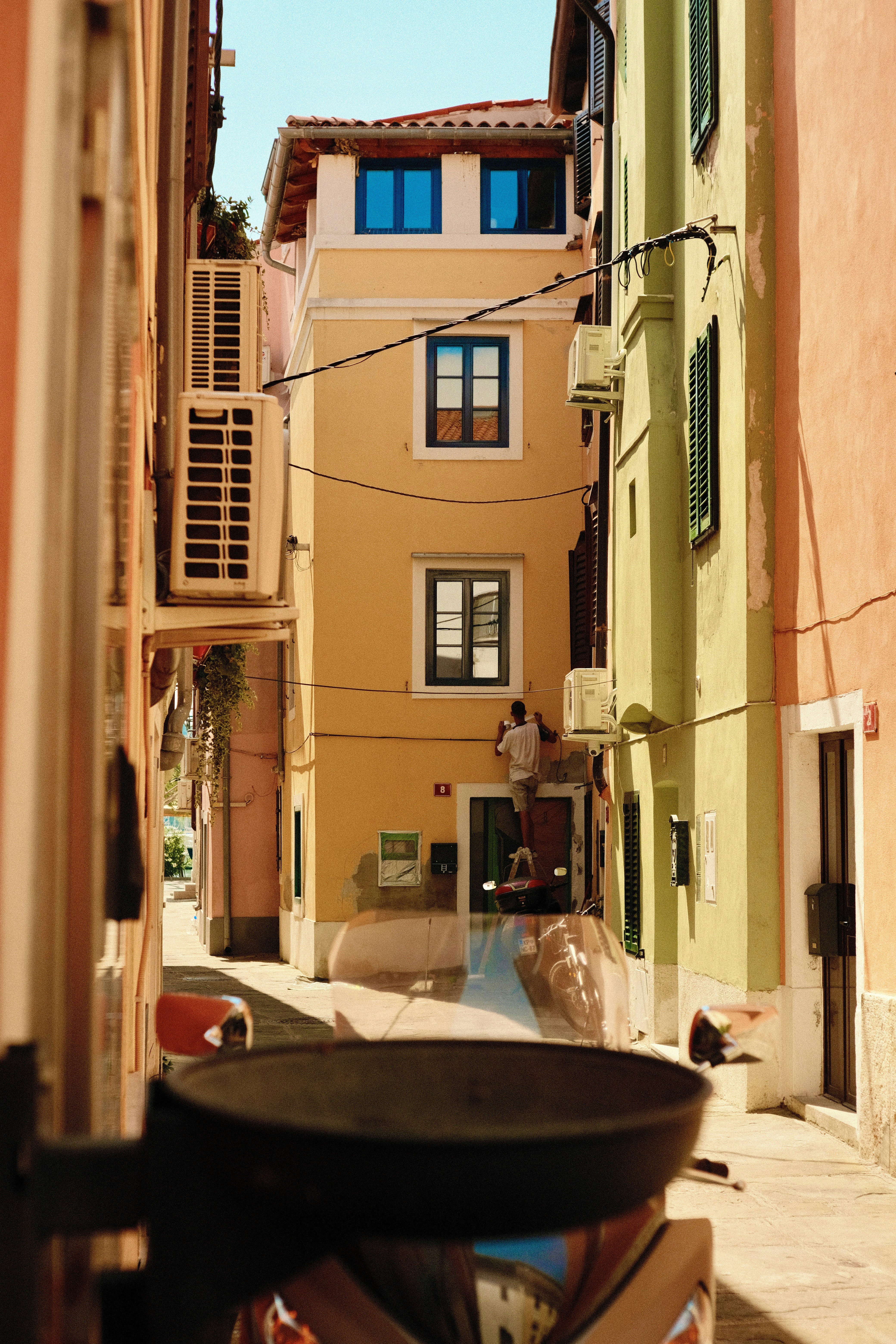Sunny Calle of Colorful Facades: A Narrow Passage Between Olive-Hued Walls