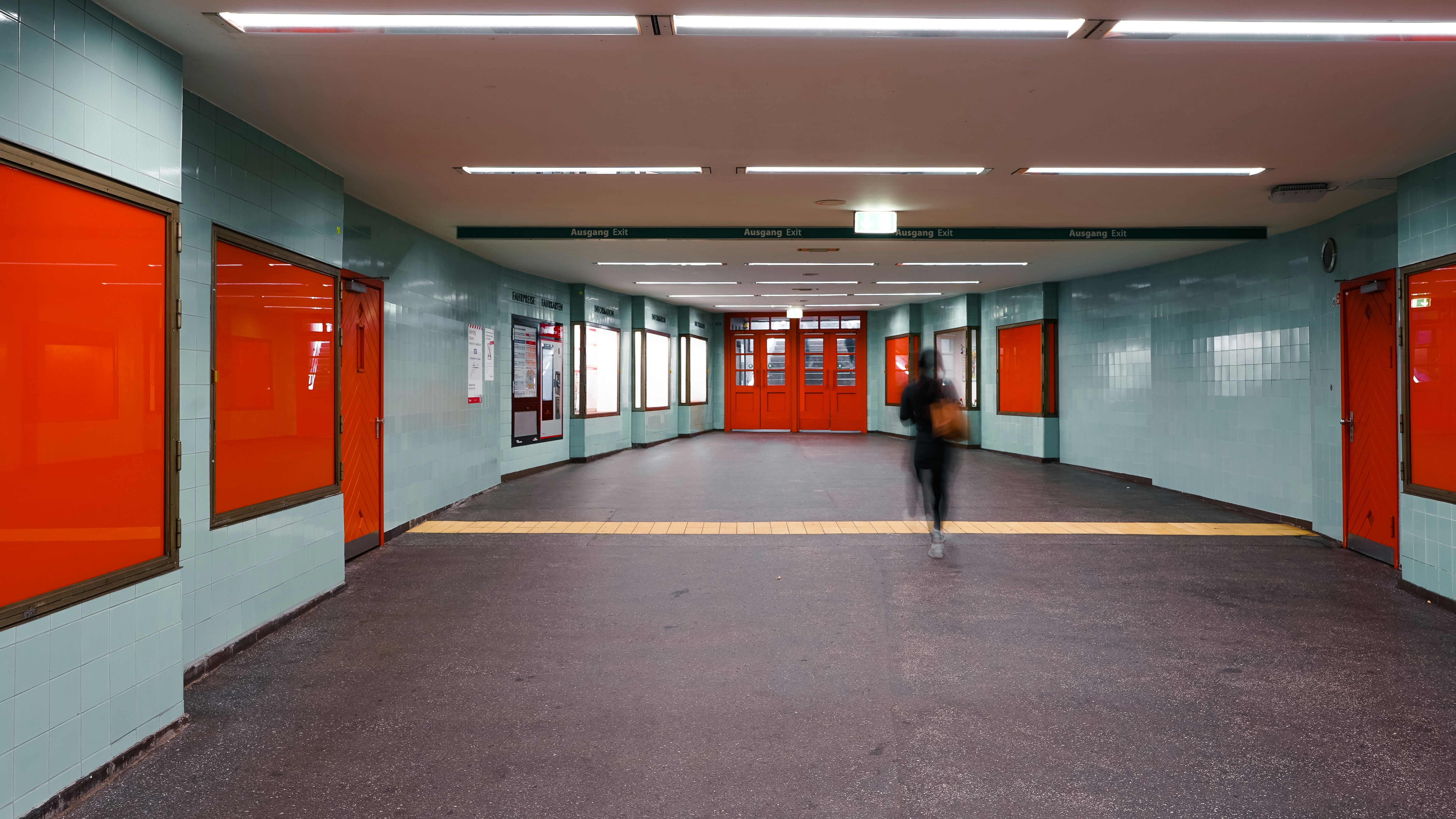 Silent Transit: A Lone Figure in a Quiet Underground Corridor