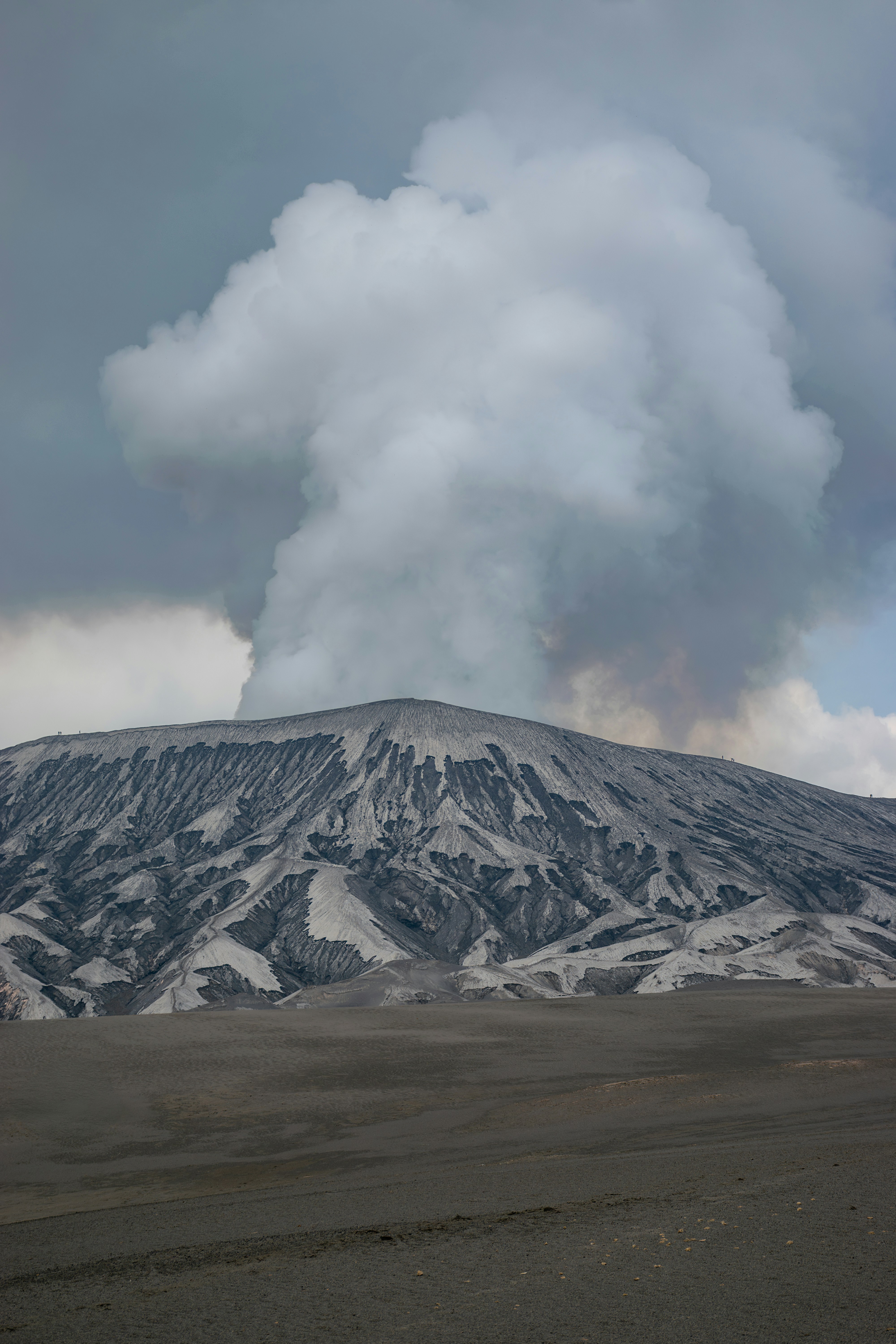 Volcanic Crown: Steam Rises Over Snow-Scored Slopes